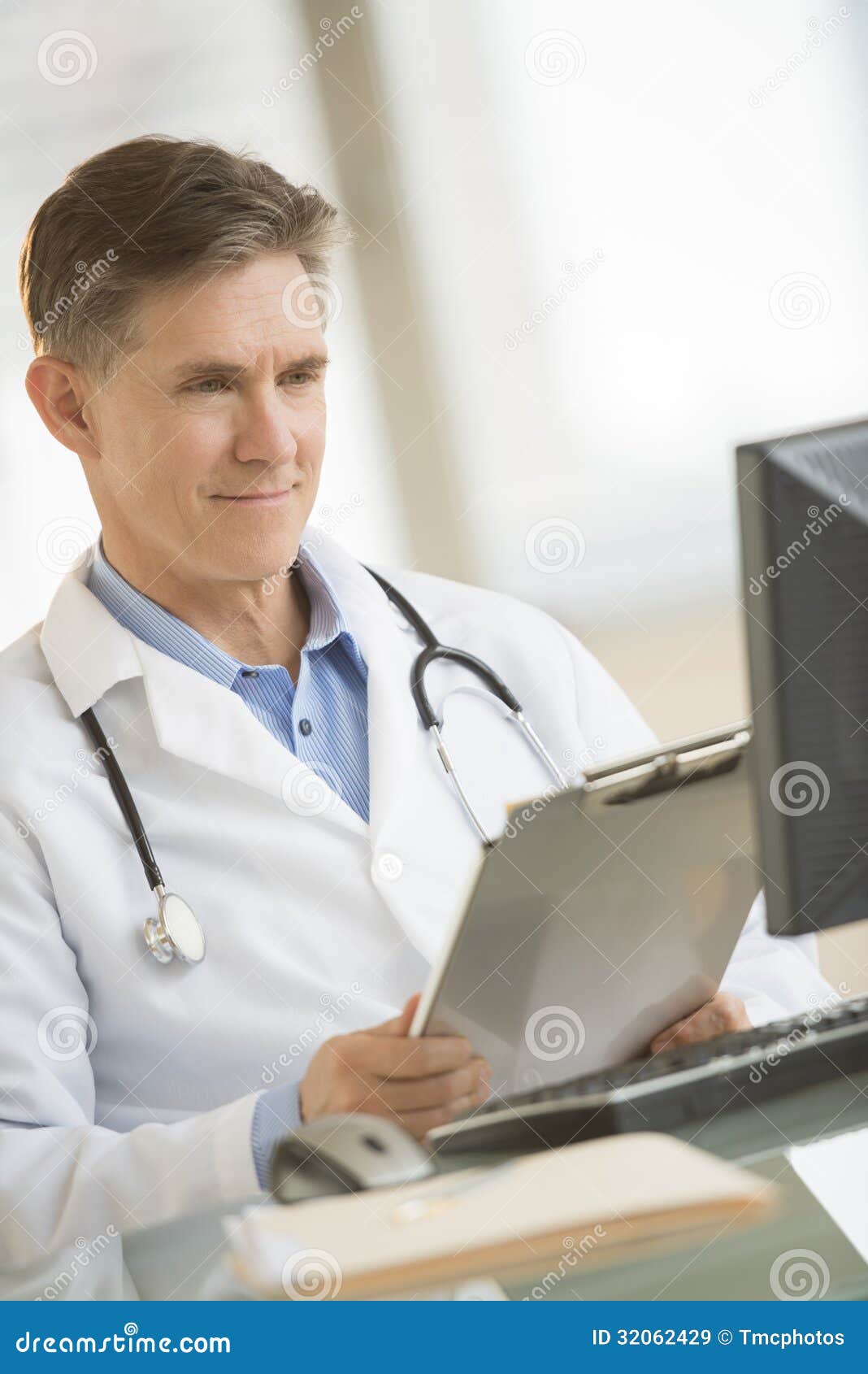Doctor Smiling while Looking at Computer Stock Image - Image of ...