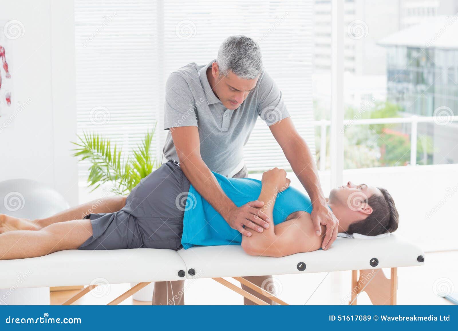 Doctor Stretching a Young Man Back Stock Image - Image of caucasian ...