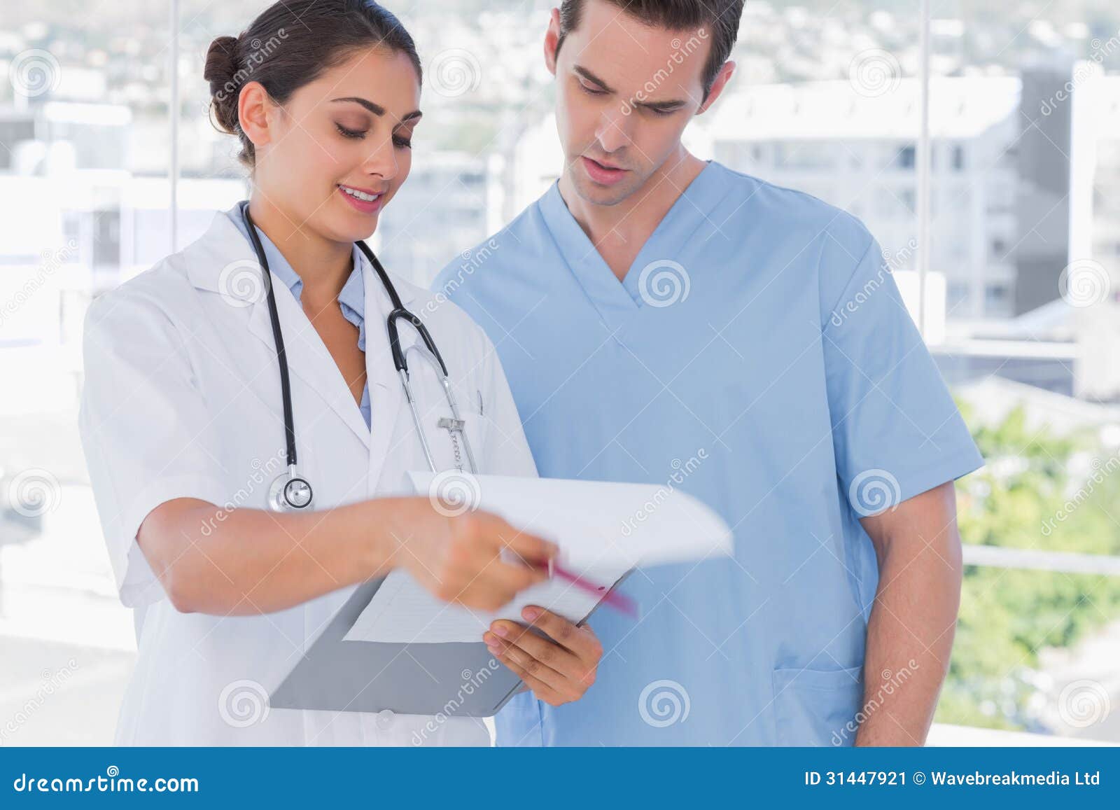 Doctor and Surgeon Going Over Notes on Clipboard Stock Image - Image of ...