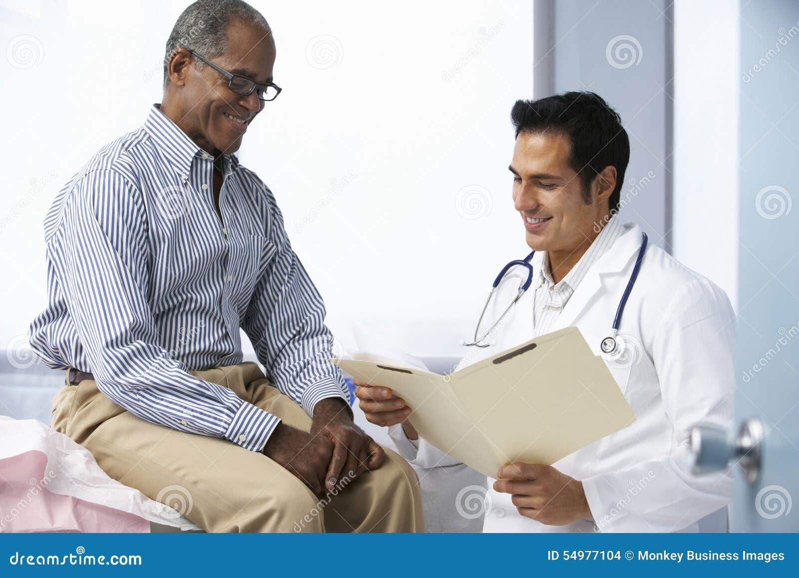 Doctor in Surgery with Male Patient Reading Notes Stock Photo - Image ...