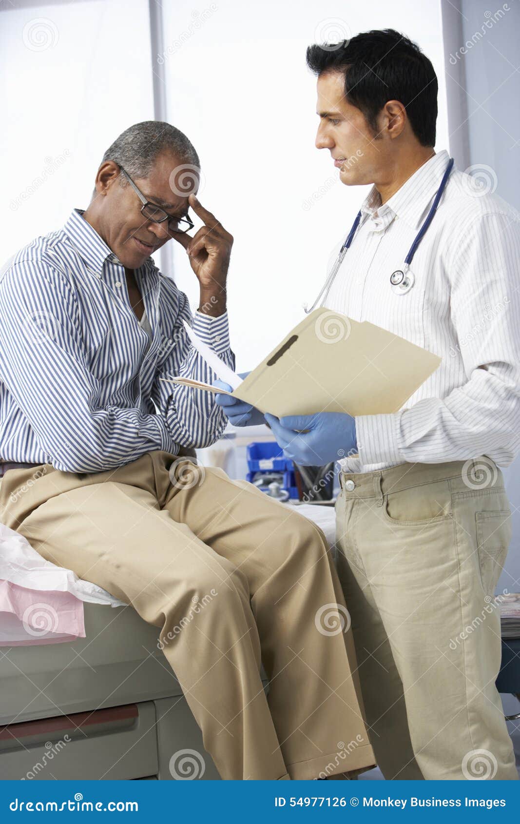 Doctor in Surgery with Male Patient Reading Notes Stock Photo - Image ...