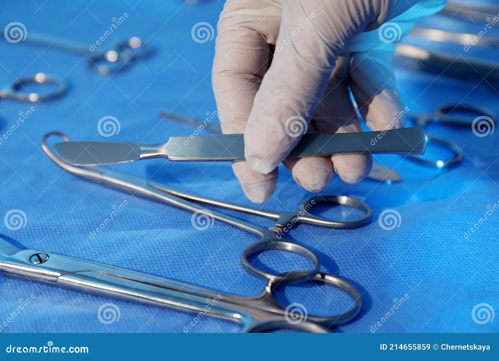 Doctor Taking Scalpel from Table with Different Surgical Instruments ...