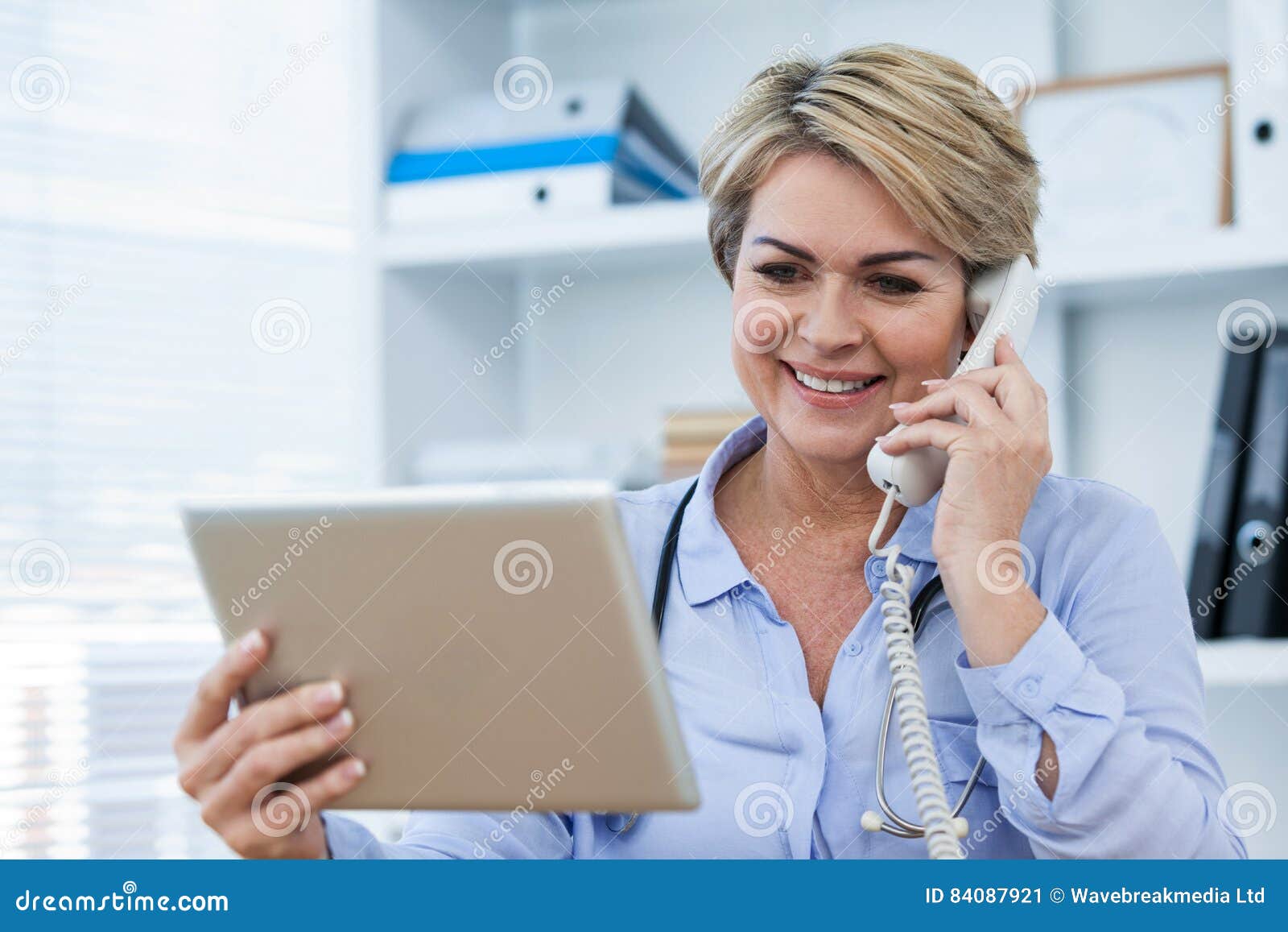 Doctor Talking on Telephone while Using Digital Tablet Stock Image ...