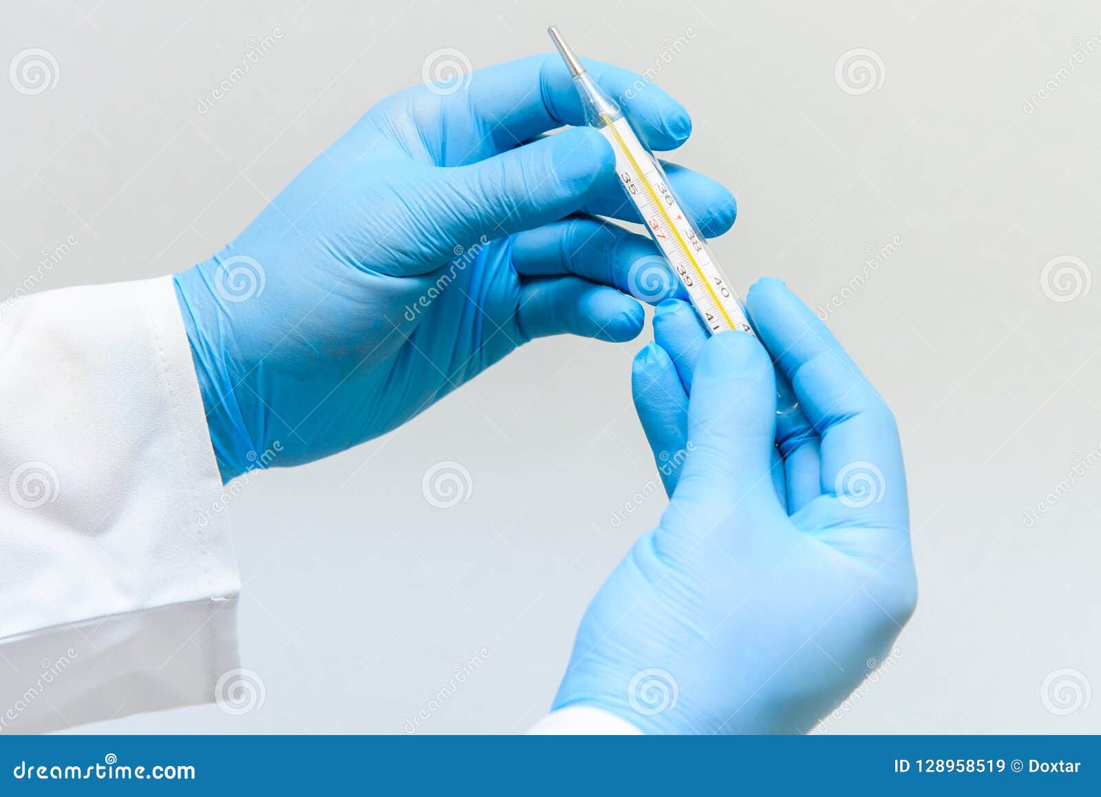 Doctor is Testing the Temperature and Holds a Thermometer in His Stock ...