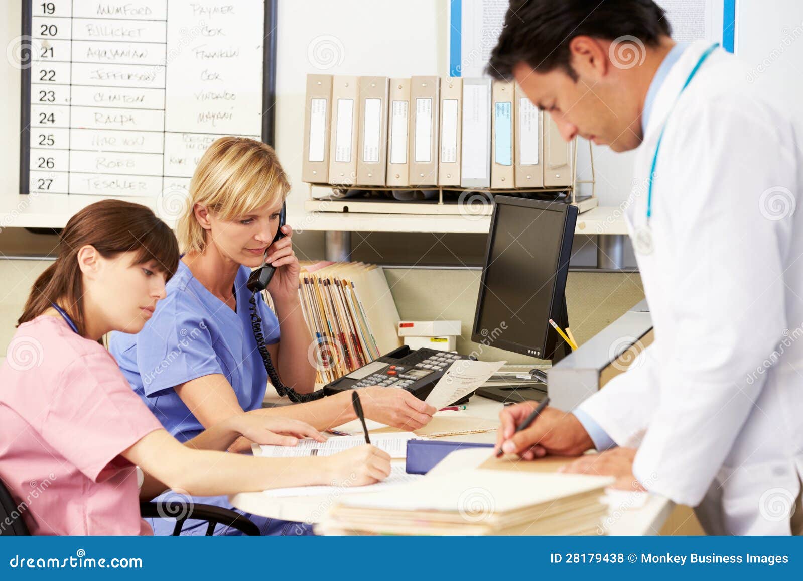 Doctor with Two Nurses Working at Nurses Station Stock Photo - Image of ...