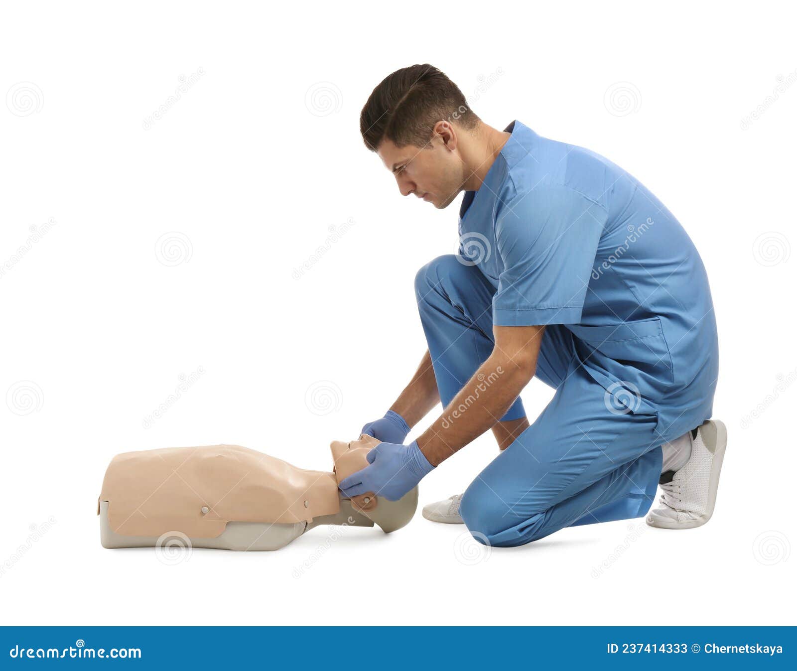Doctor in Uniform Practicing First Aid on Mannequin Against White ...