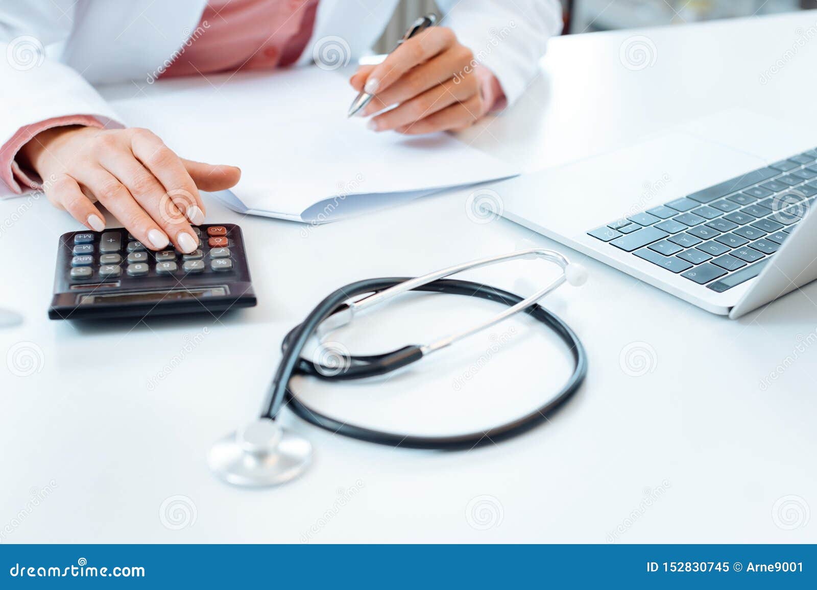 Doctor Using Calculator Writing Bills and Doing Bookkeeping Stock Image ...
