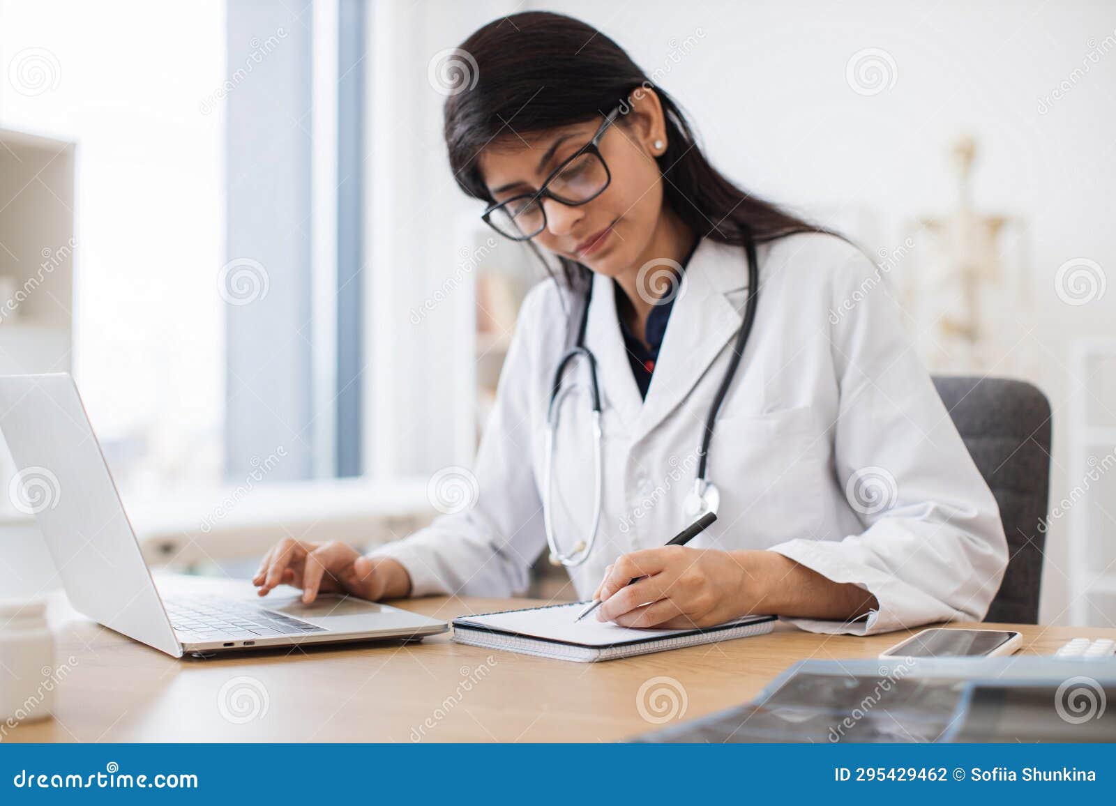 Doctor Using Computer while Sitting at Desk in Health Center Stock ...