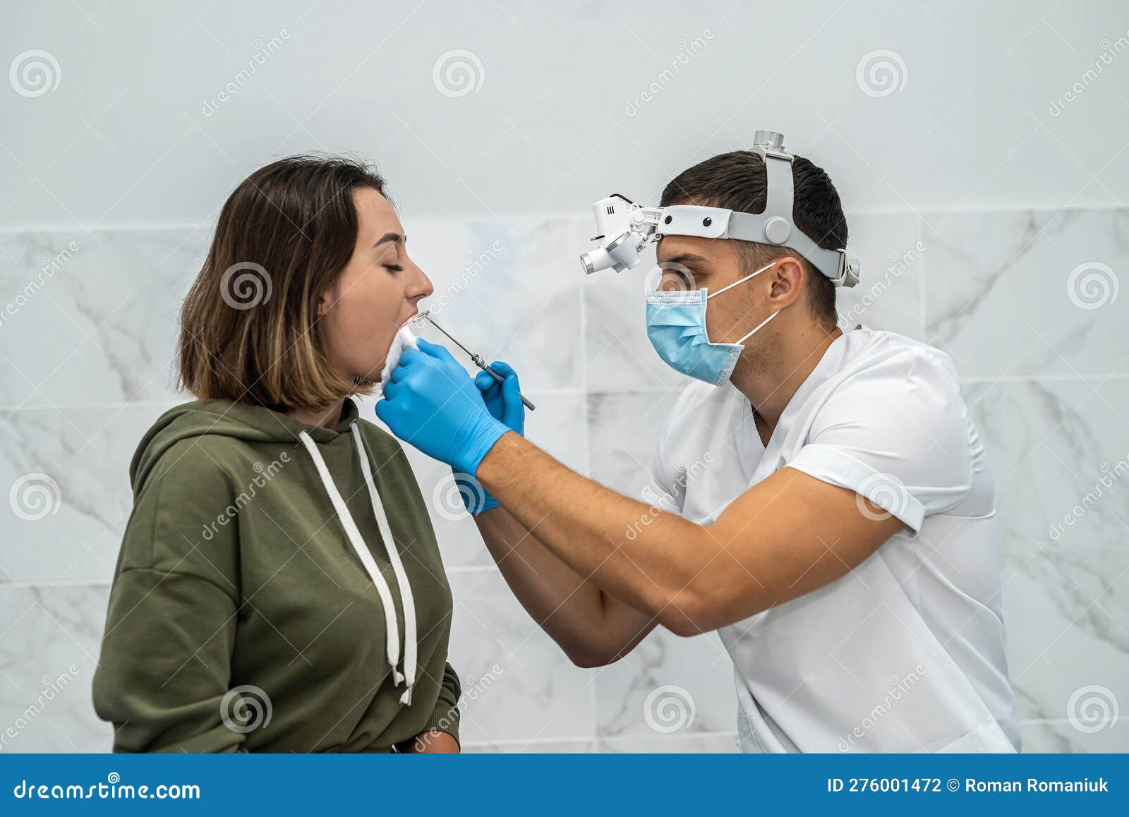 Doctor Using An Inspection Spatula To Examine A Patientand X27s Throat