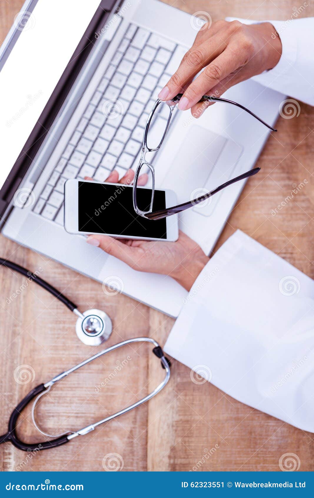 Doctor Using Smartphone on Wooden Desk Stock Image - Image of examining ...