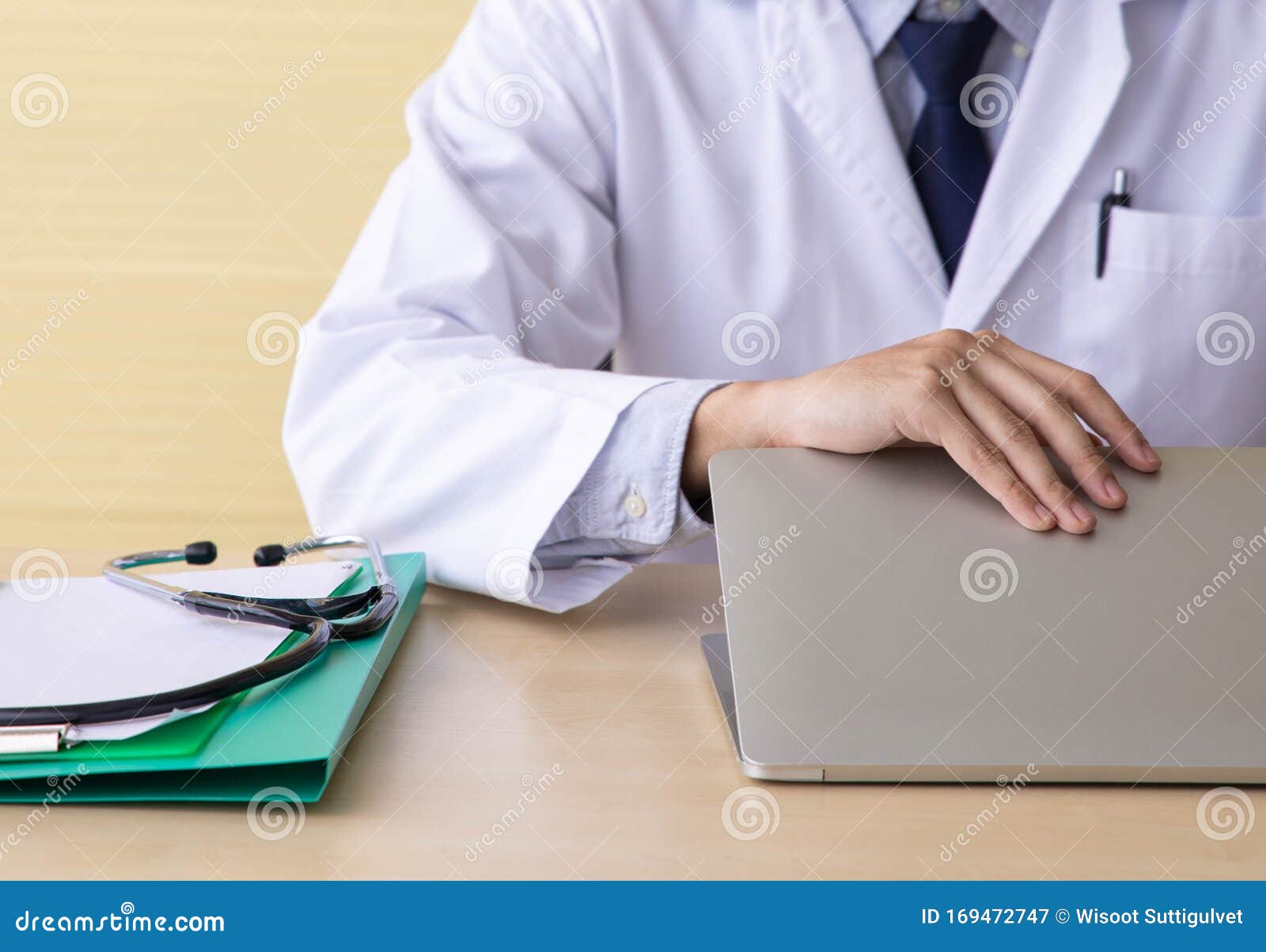 Doctor Working with Laptop Computer and Writing on Paperwork Stock ...