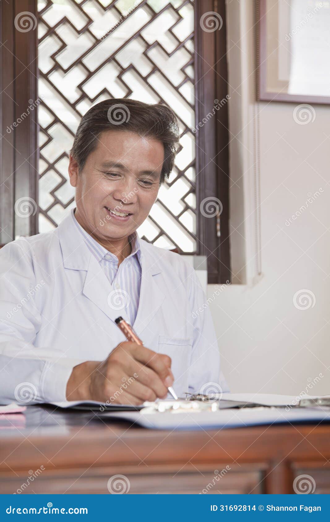 Doctor Writing at His Desk stock photo. Image of confidence - 31692814