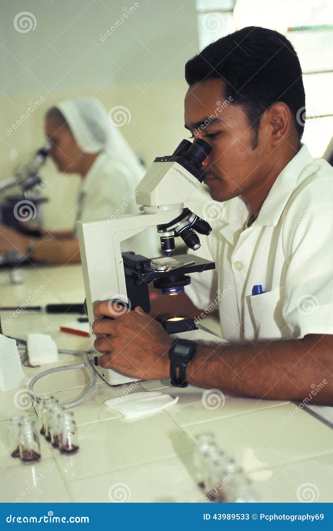 Doctores Que Miran En El Microscopio Foto de archivo editorial - Imagen ...