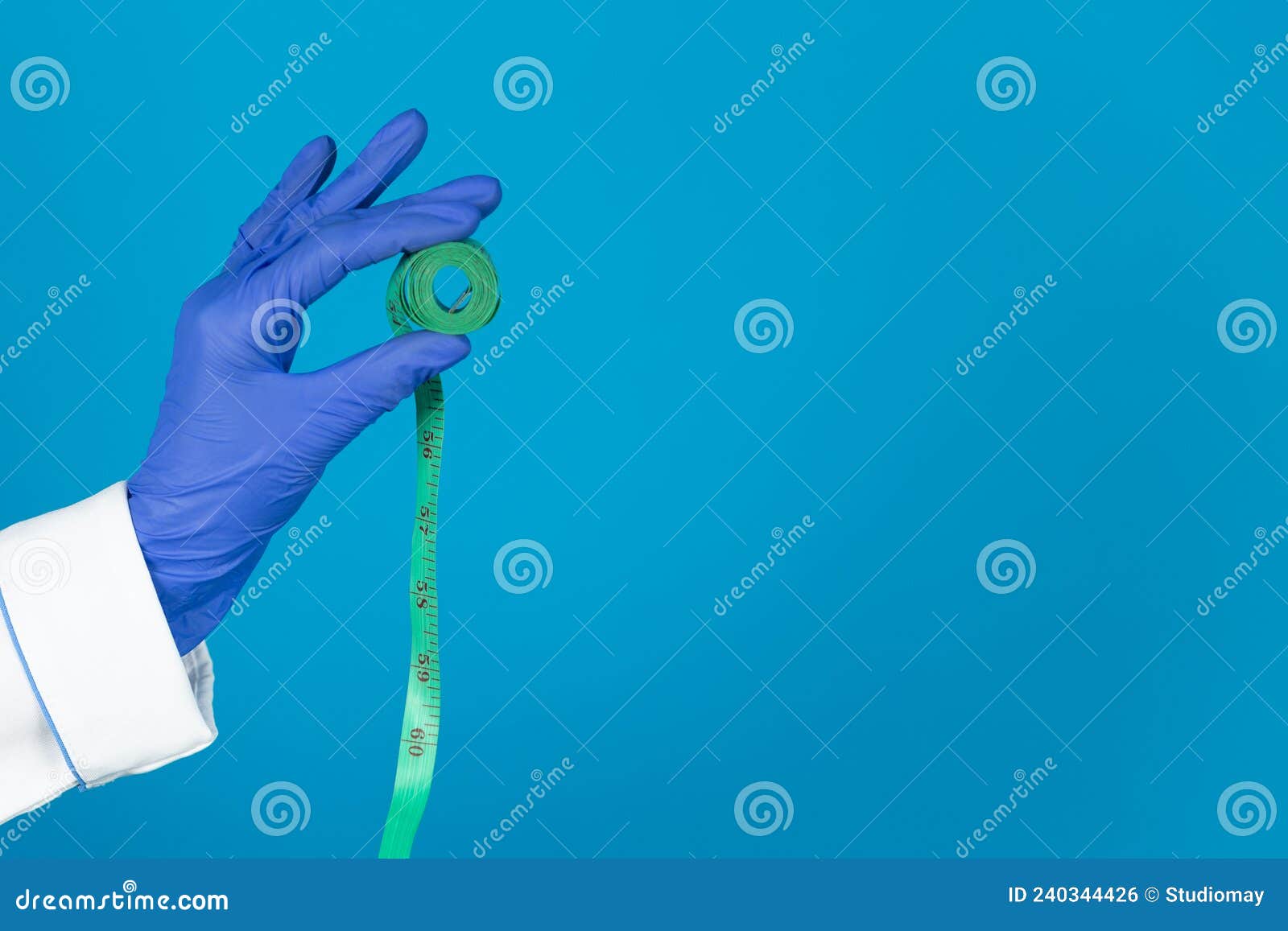 Doctors Hand in a Glove Holds a Measuring Tape on a Blue Background ...