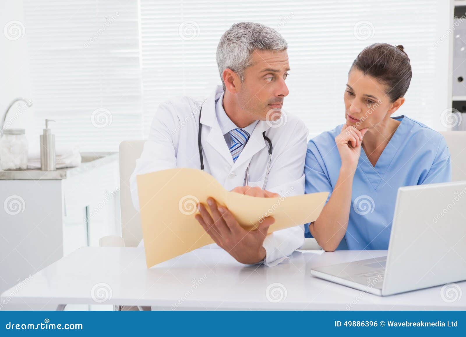 Doctors looking at files stock photo. Image of concentrate - 49886396