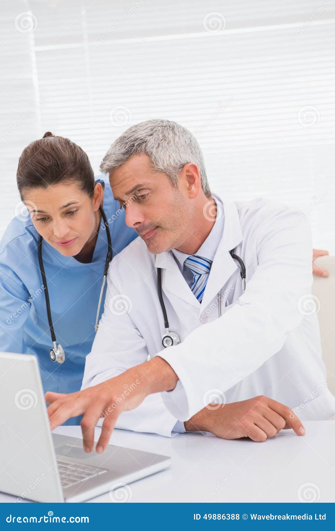 Doctors looking at laptop stock photo. Image of explaining - 49886388