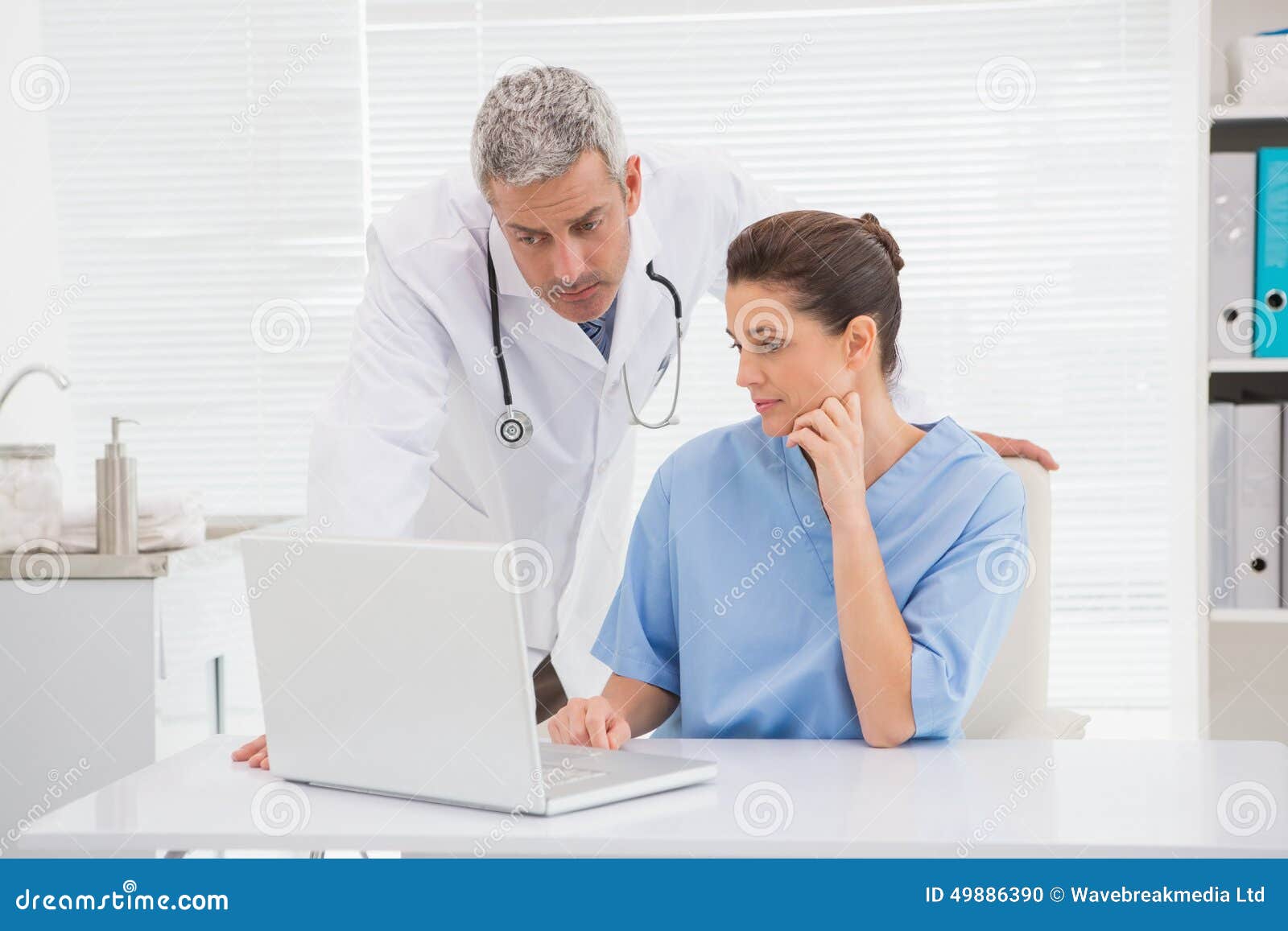 Doctors looking at laptop stock photo. Image of conversation - 49886390