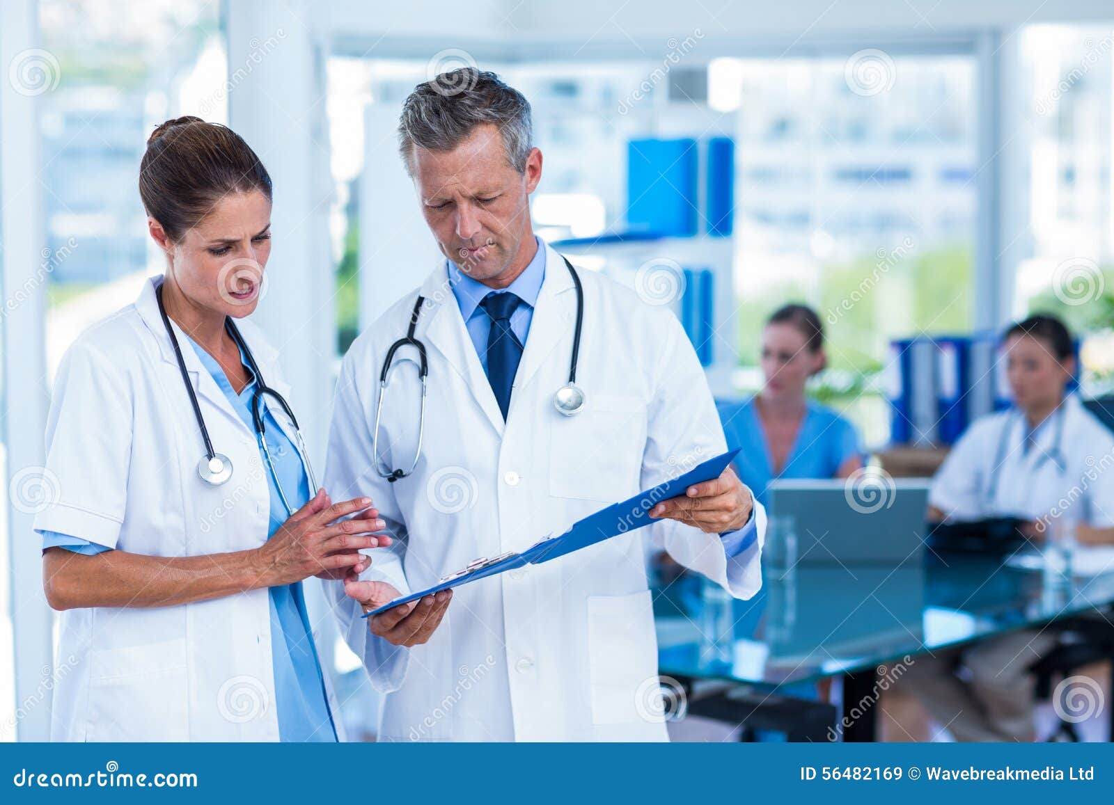 Doctors Looking Together at Clipboard Stock Image - Image of healthcare ...