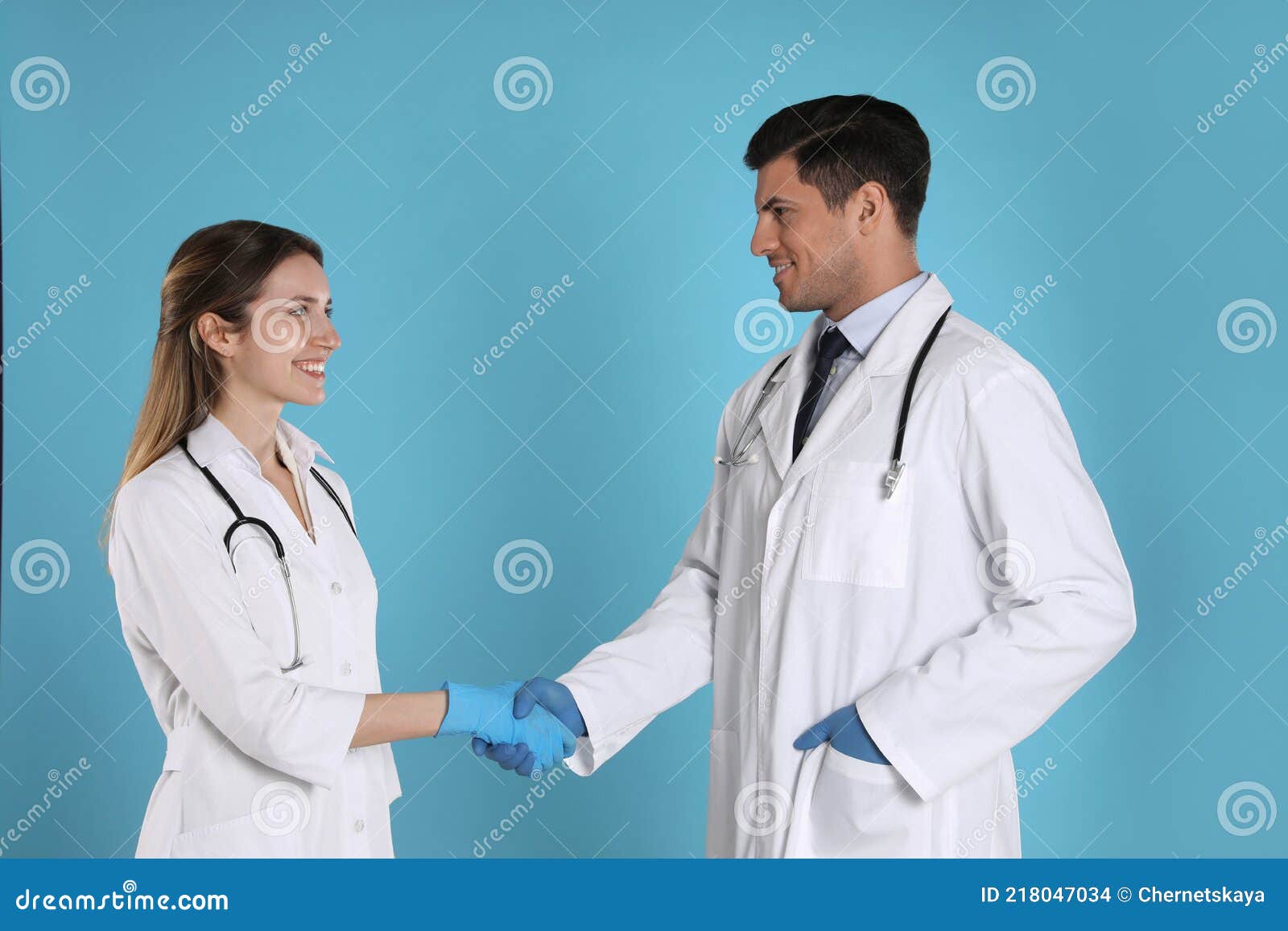 Doctors Shaking Hands on Light Blue Background Stock Photo - Image of ...