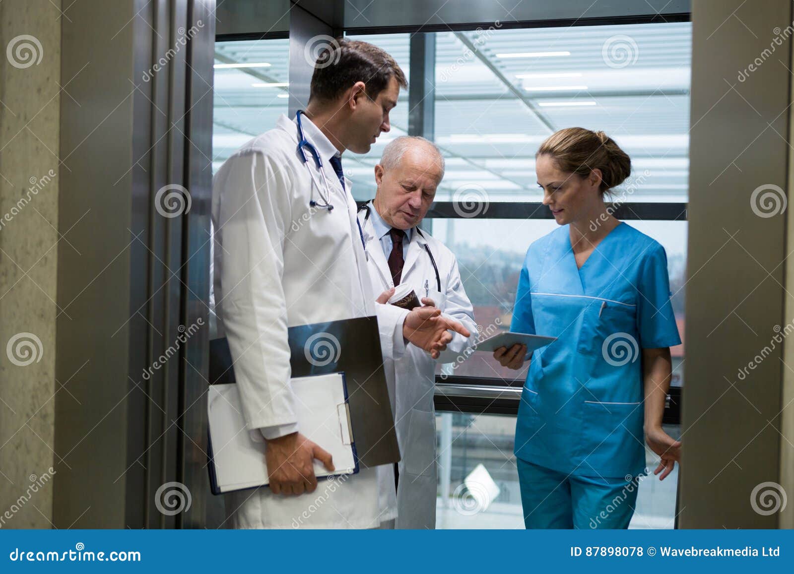 Doctors and Surgeon Using Digital Tablet in Elevator Stock Photo ...