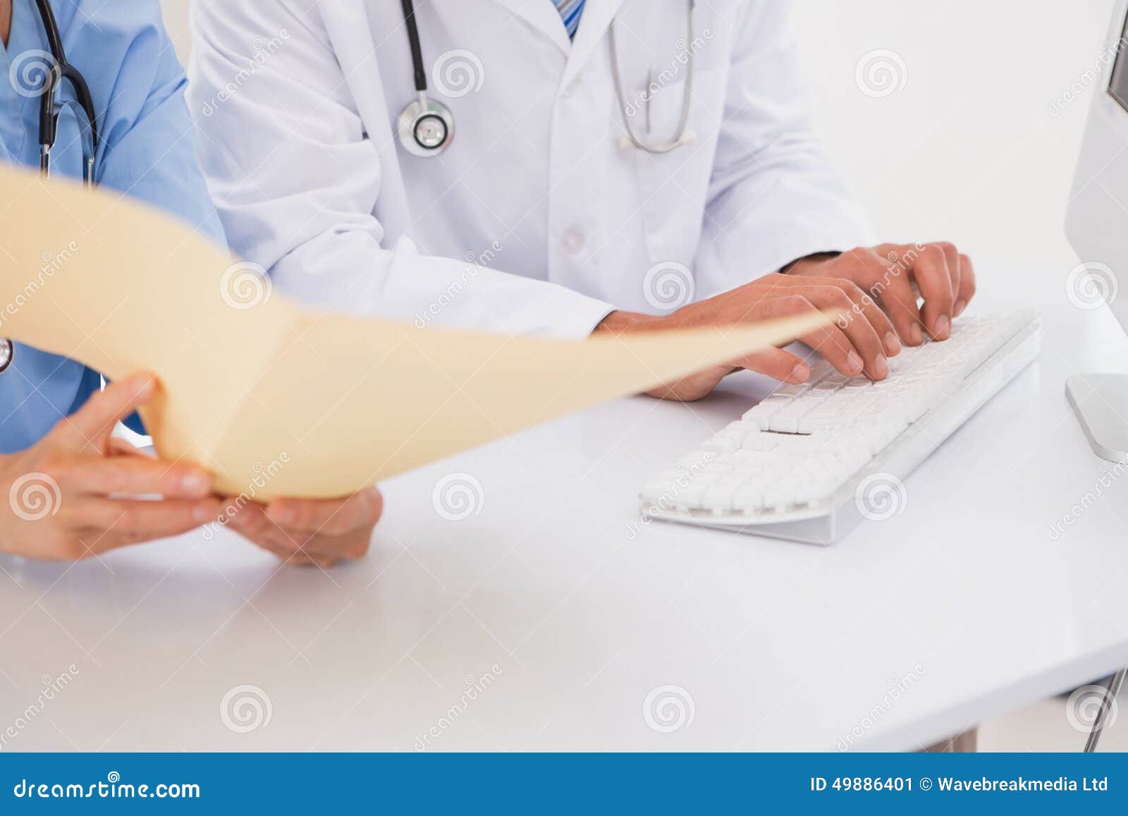 Doctors Using Computer Looking at Files Stock Image - Image of serious ...