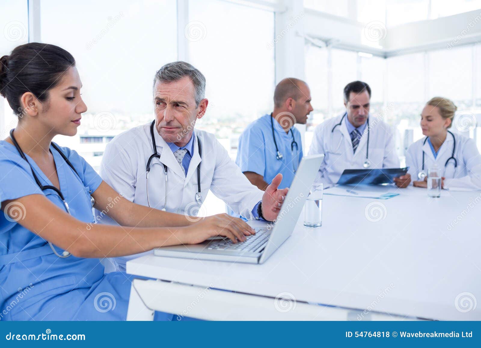 Doctors Using Computer Whiles Theirs Colleagues Looking at Xray Stock ...