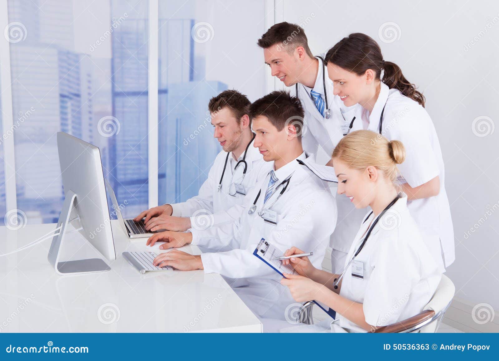 Doctors Working Together on Computer in Hospital Stock Image - Image of ...