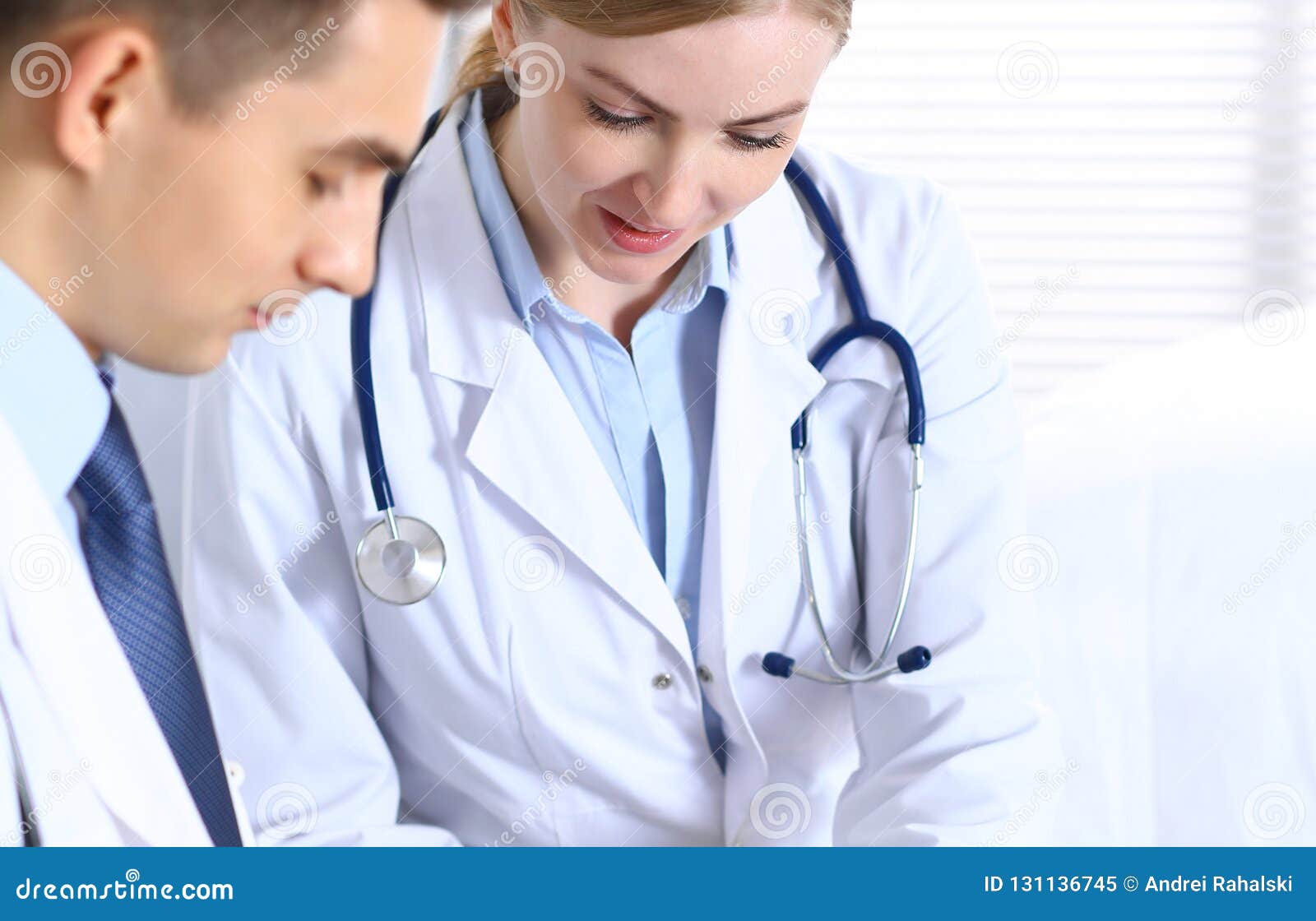 Doctors Writing Papers Using Clipboard. Physicians Discussing ...