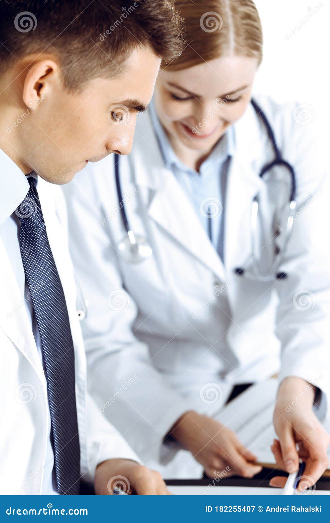 Doctors Writing Papers Using Clipboard. Physicians Discussing ...