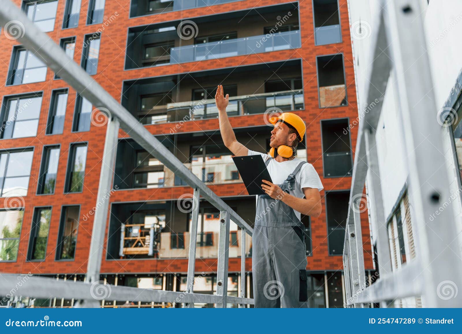 With Documents in Hands. Young Man Working in Uniform at Construction ...
