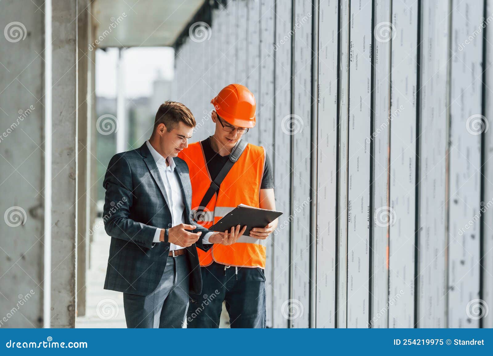 With Documents. Man in Suit and Handyman in Orange Protective Wear is ...