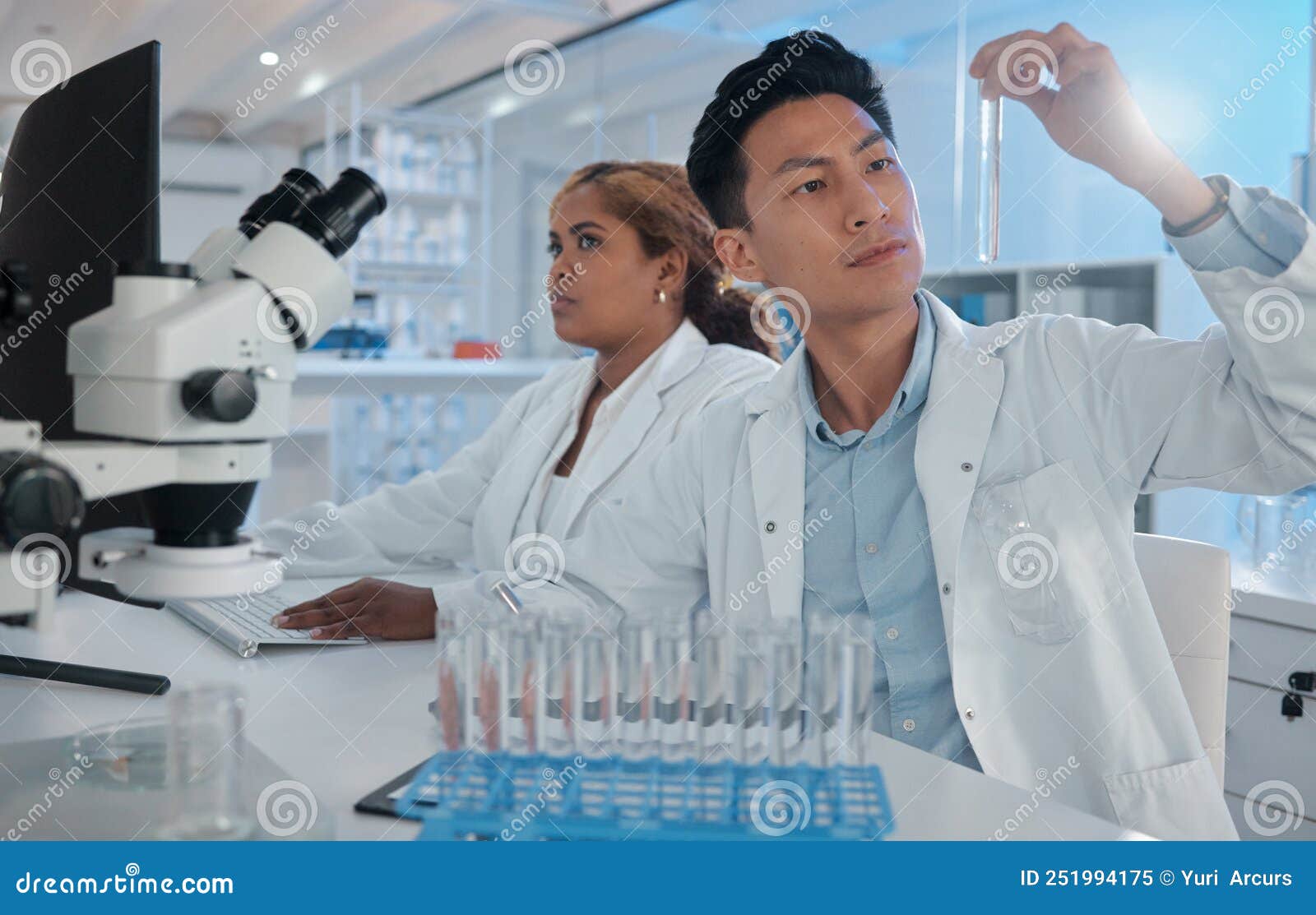 Does it Catch the Light. a Young Male Lab Tech Analysing a Sample in ...