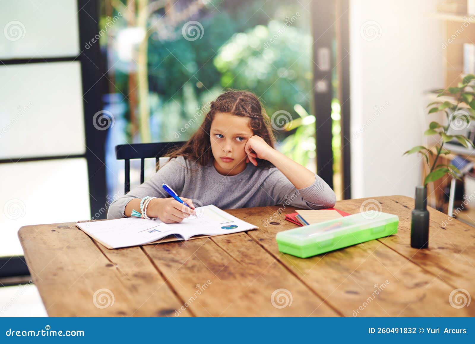 She Does Not Find Homework Fun. a Young Girl Doing Homework Inside ...