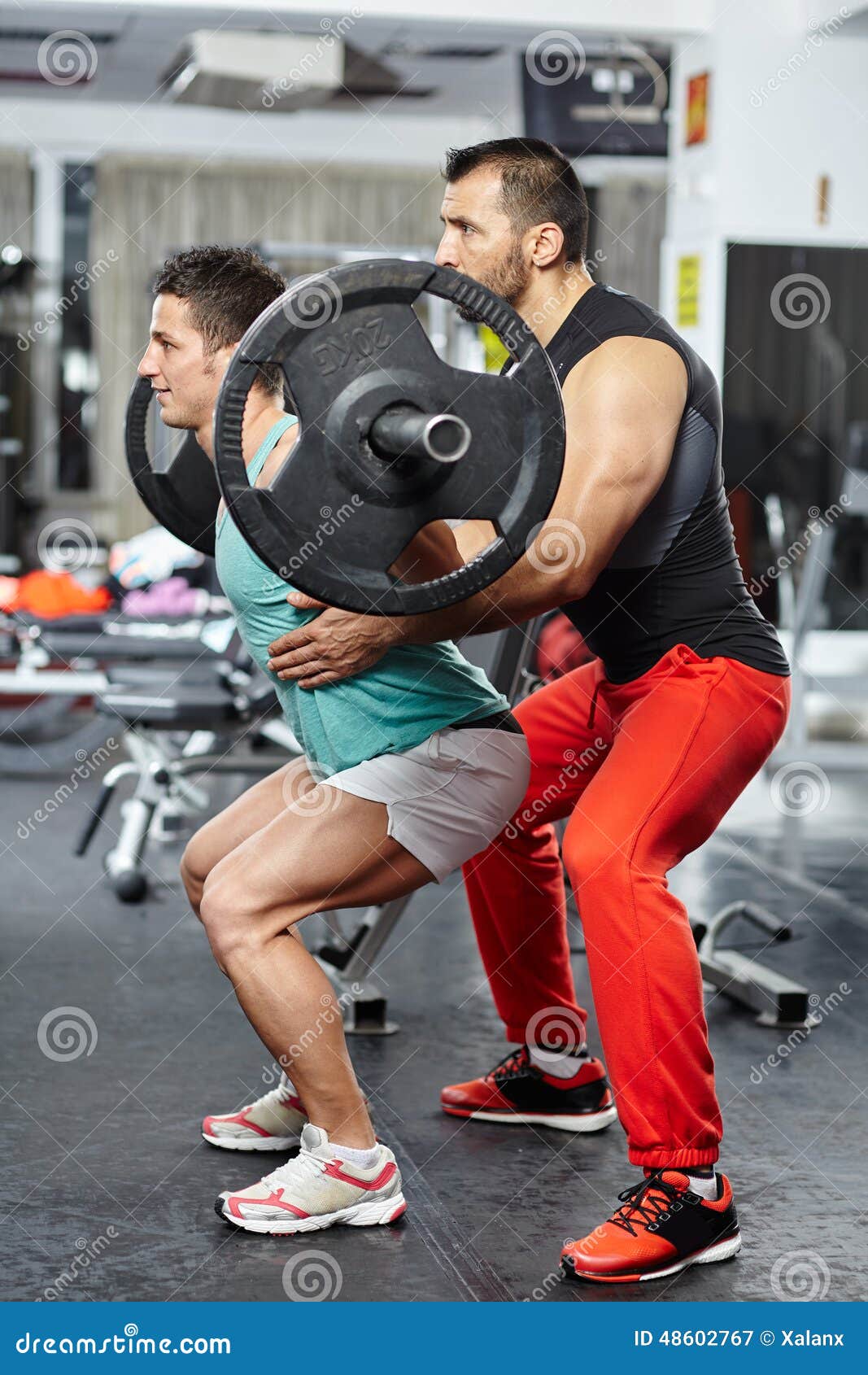 Doing Barbell Squats with Personal Instructor Stock Image - Image of ...