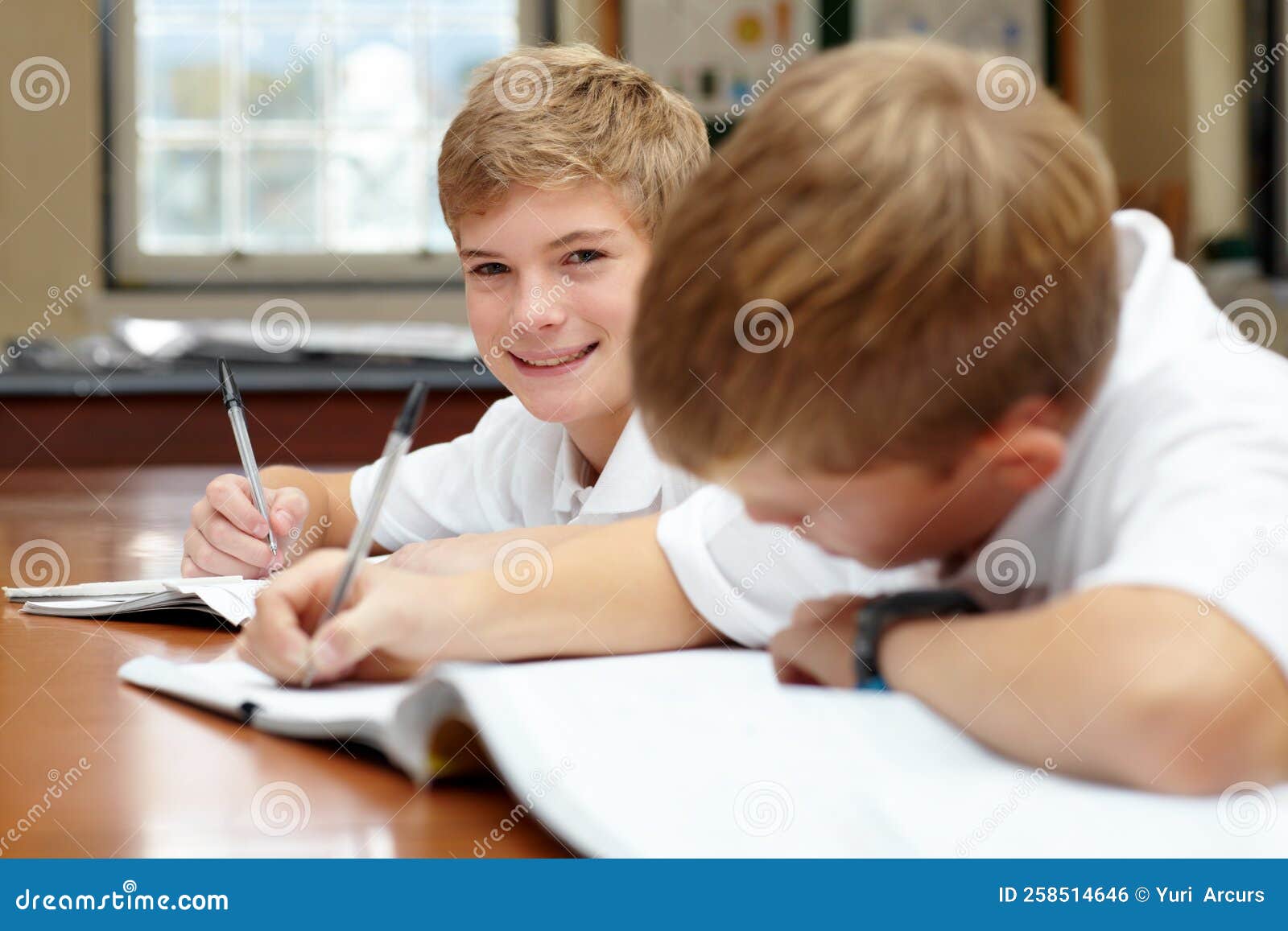 Doing His Schoolwork with a Smile. Two Young Schoolboys Doing Their ...