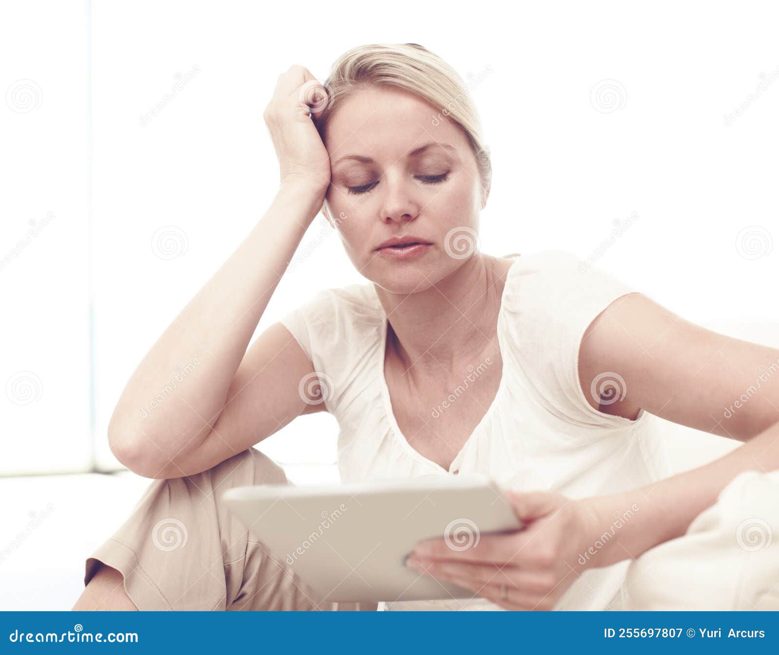Doing a Little Reading. an Attractive Blonde Woman Using a Tablet while ...