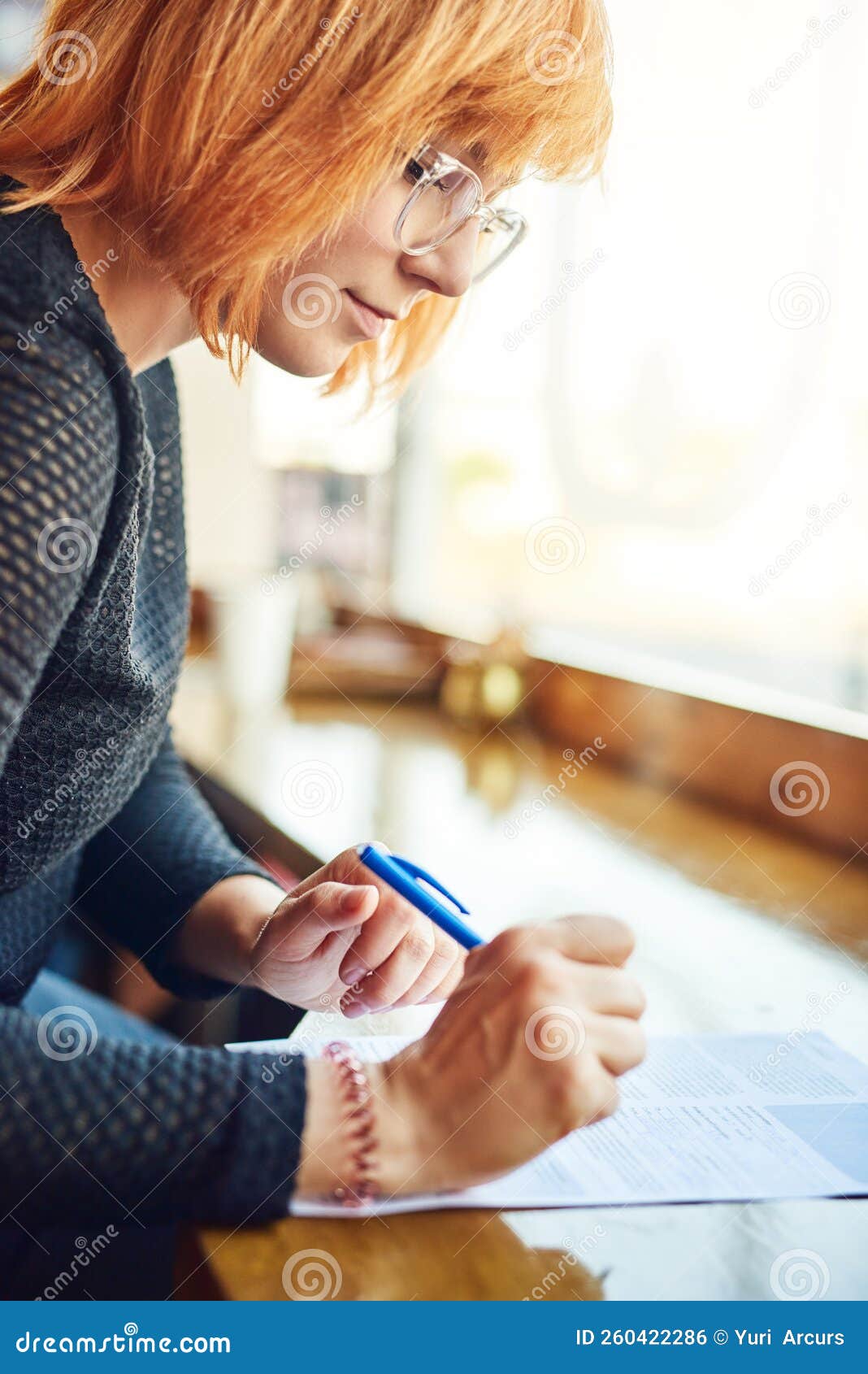 Doing Some Paperwork at the Corner Cafe. a Young Woman Doing Paperwork ...
