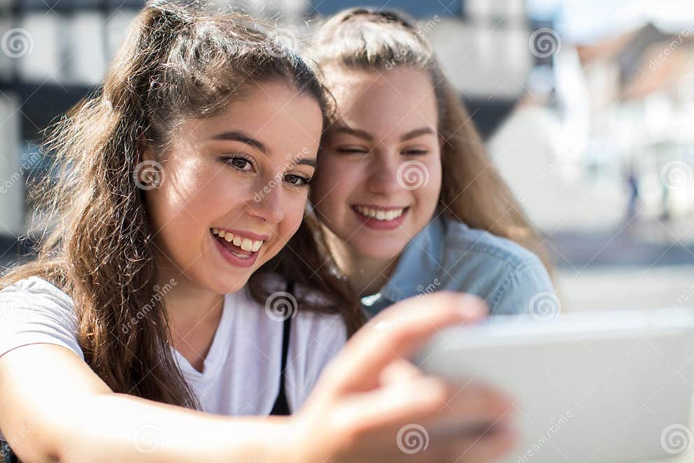 Dois Adolescentes Que Tomam Selfie No Telefone Celular Fora Imagem De