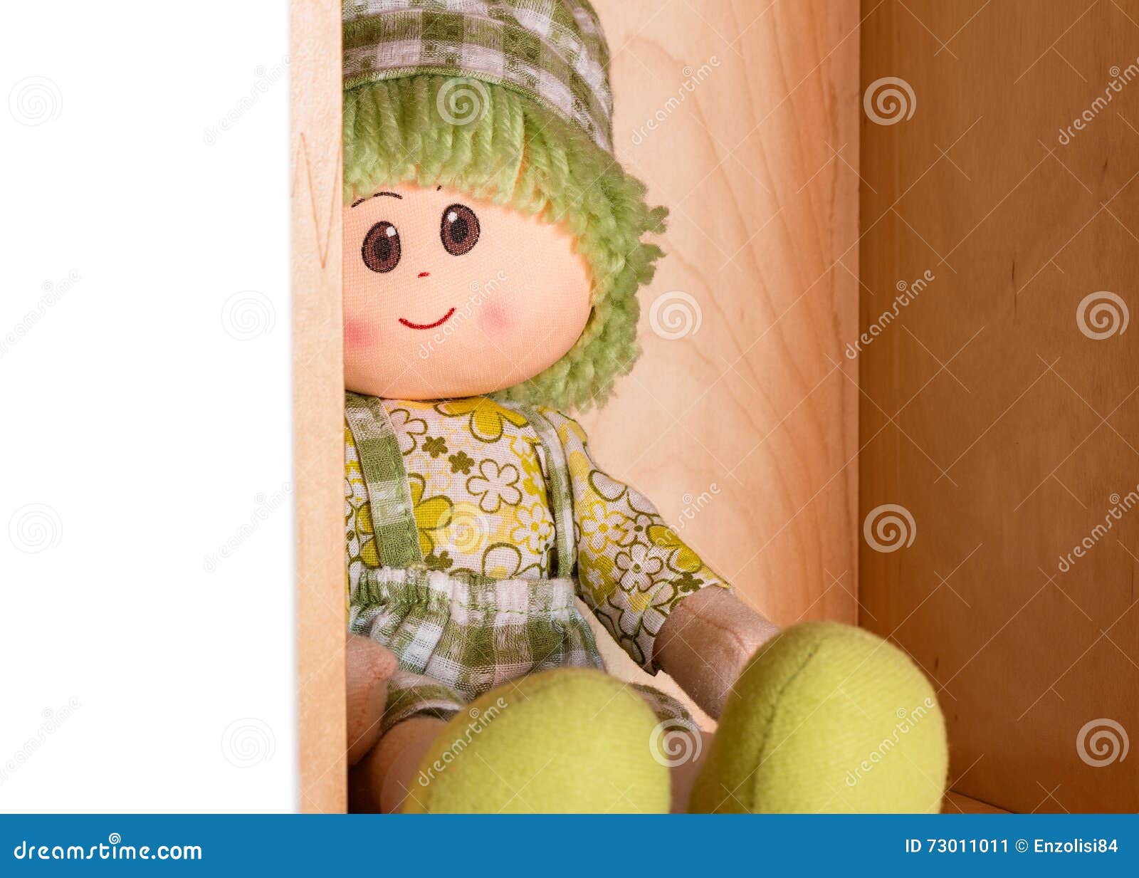 A Green Doll Watching Tablet In Book Cabinet Stock Image ...