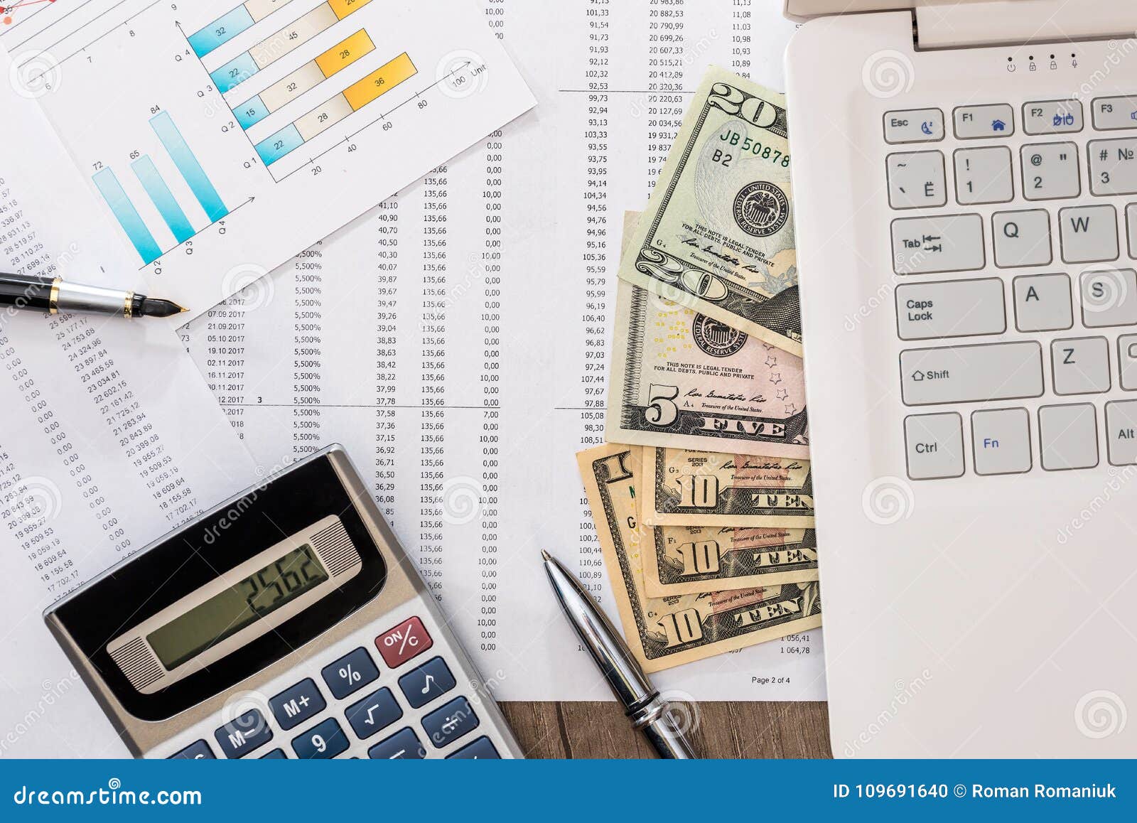 Dollar Bills on a Table with Graph Chart and Laptop, Pen Stock Photo ...