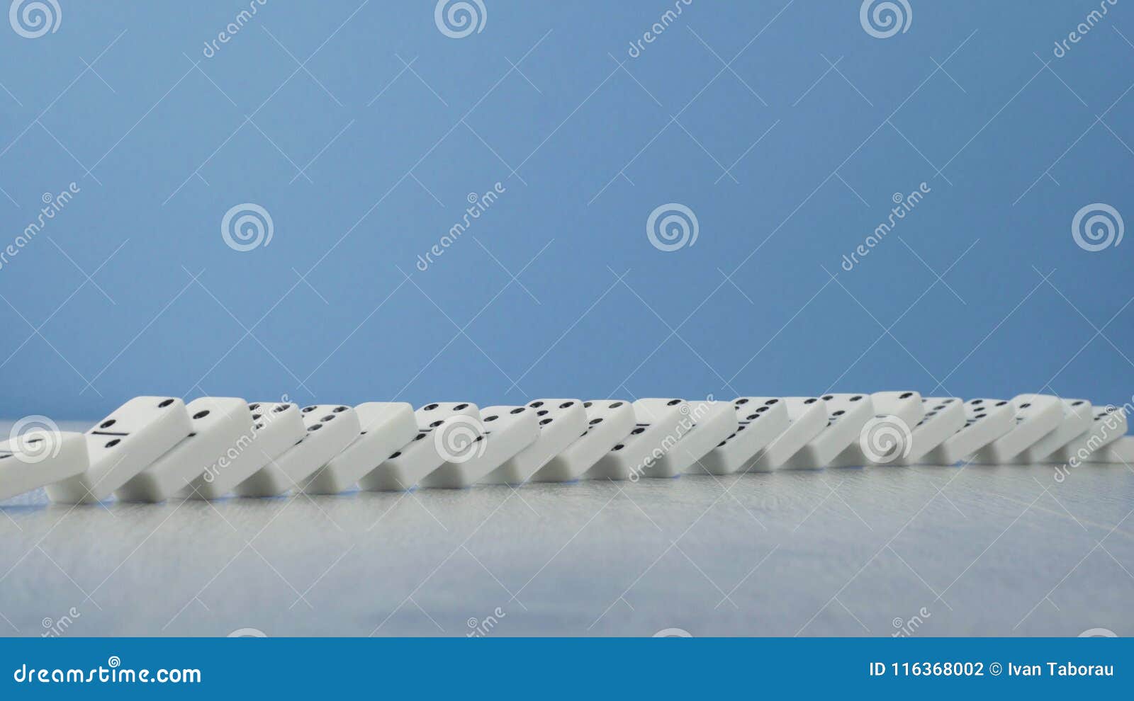 Domino Effect - a Series of Dominoes Falling Down the Chain on Blue ...