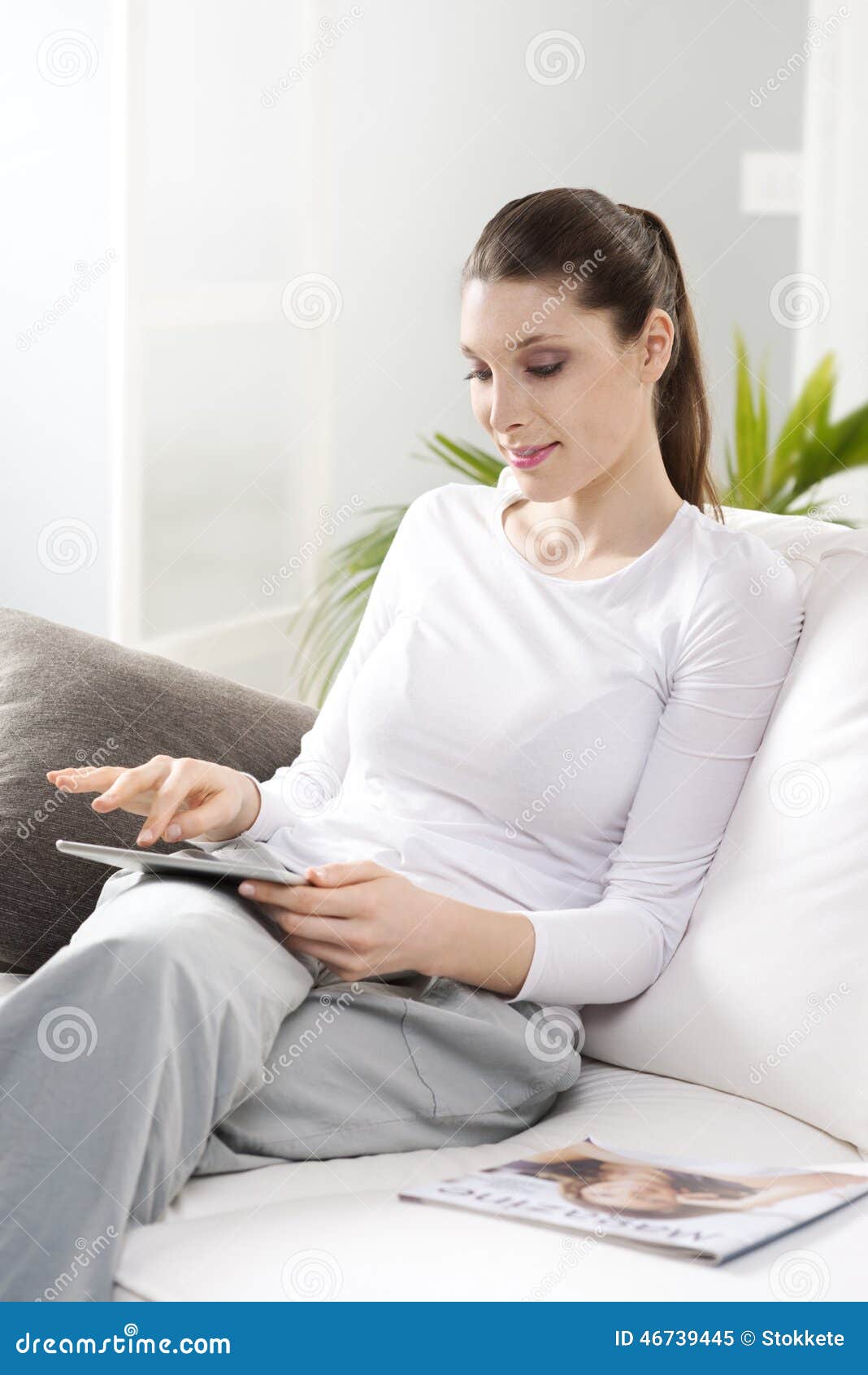 Donna Che Si Rilassa Sul Sofà Con La Compressa Immagine Stock ...