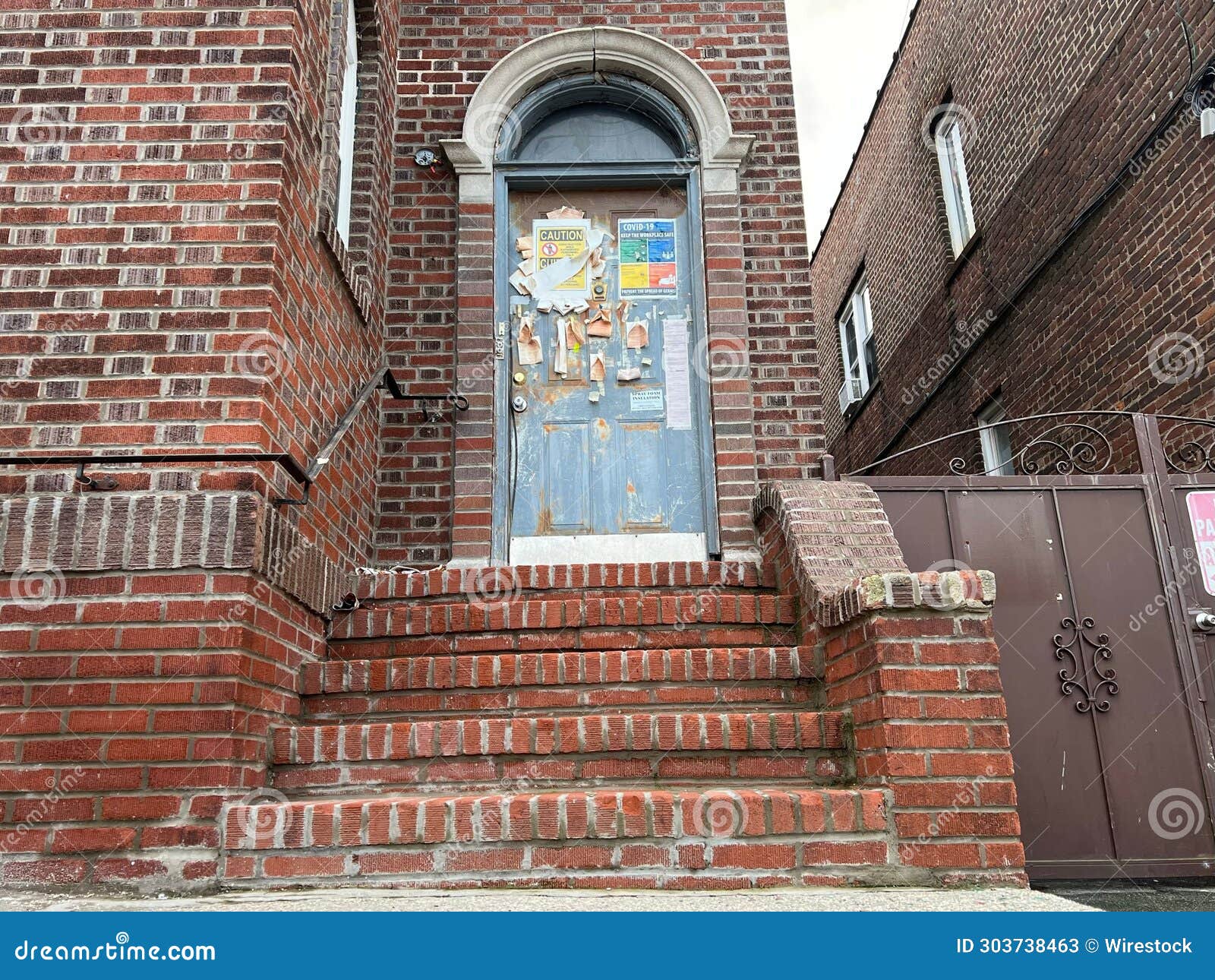 Door of a Red Brick Building with Multiple Caution Signs Stock Image ...