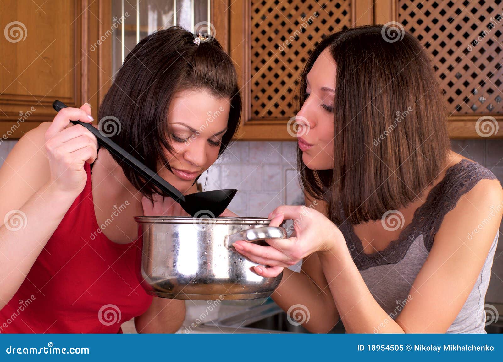 Dos Mujeres Hermosas Que Intentan Cocinar Imagen de archivo - Imagen de ...