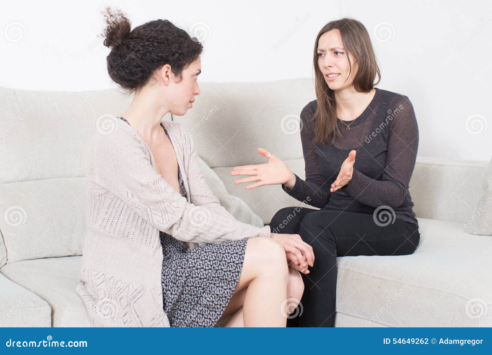 Dos Mujeres Que Hablan En Un Sofá Foto de archivo - Imagen de escuche ...