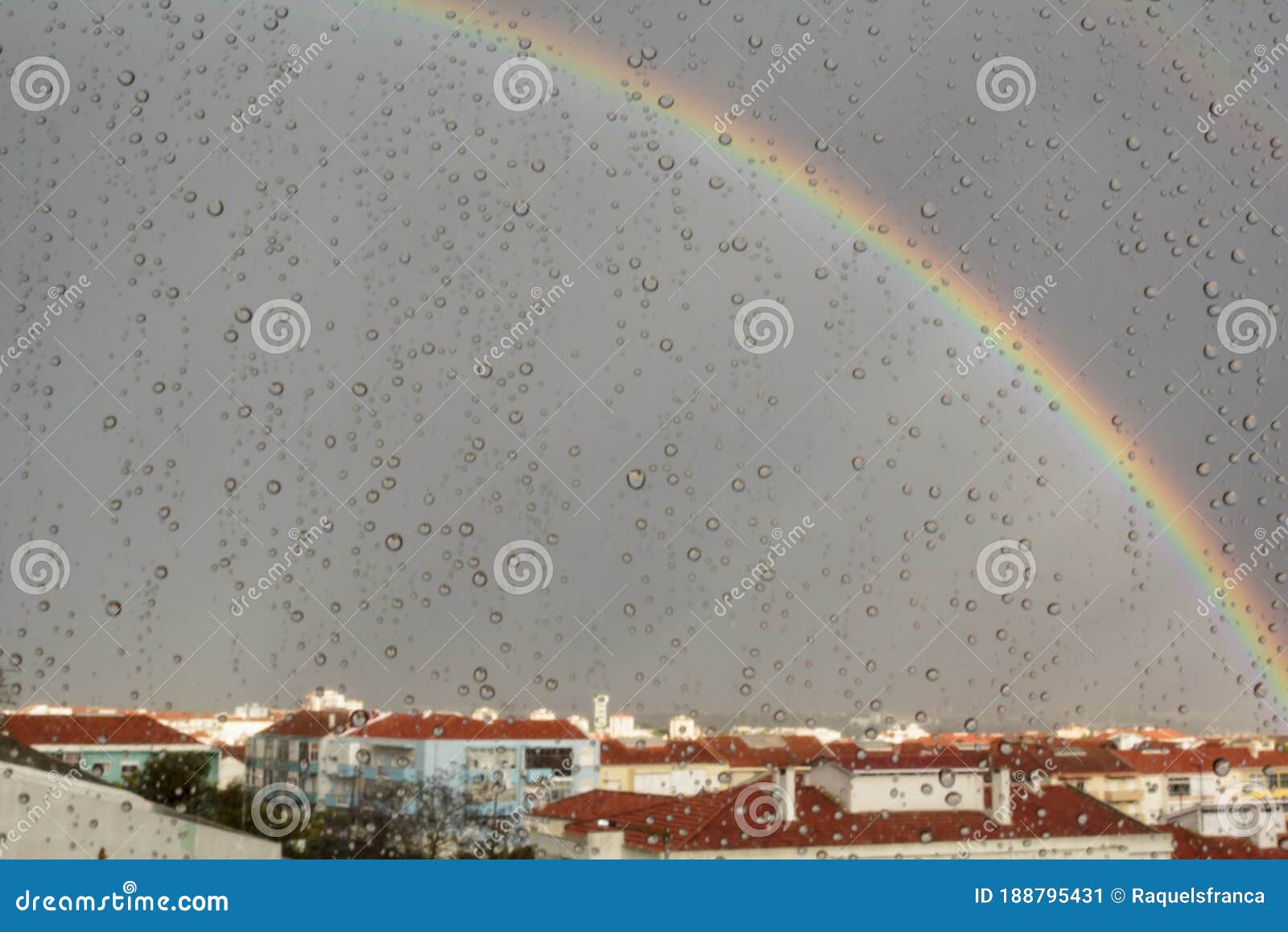 Double Rainbow Over Buildings Seen through Window with Raindrops Stock ...