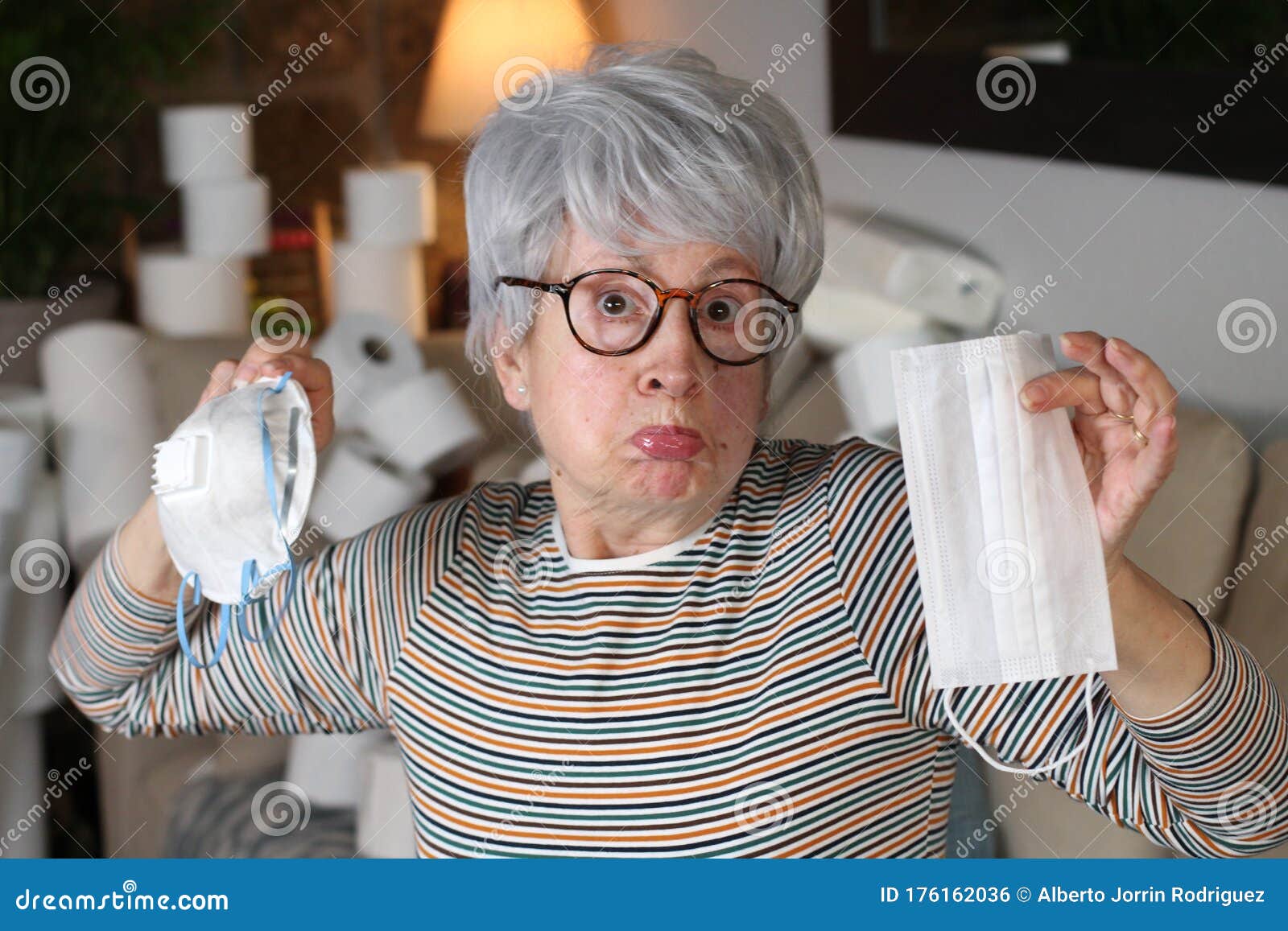 Doubtful Senior Woman Holding Two Types of Masks Stock Photo - Image of ...