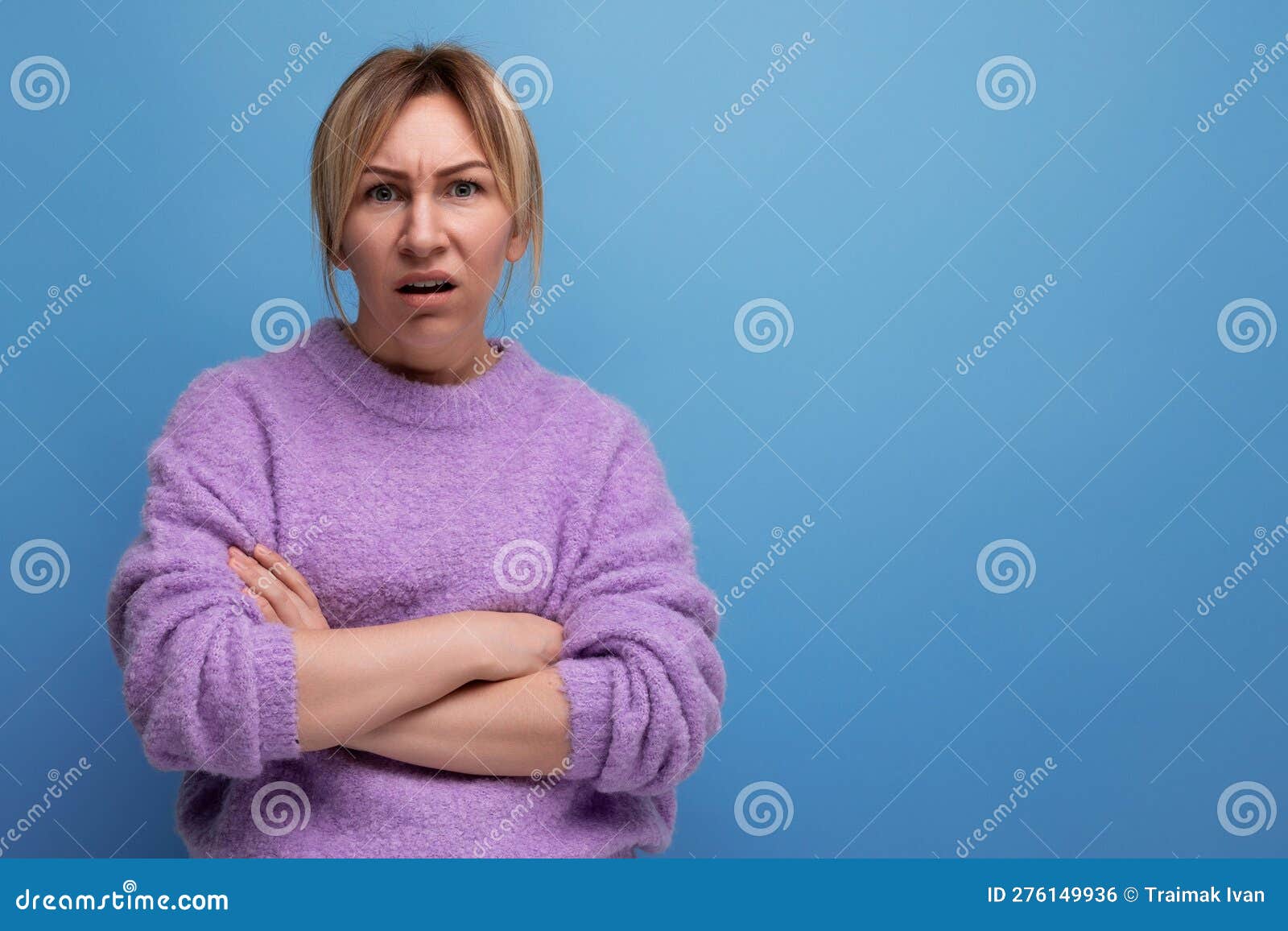 Doubting Blond Woman Looking Contemptuously at Camera on Blue ...