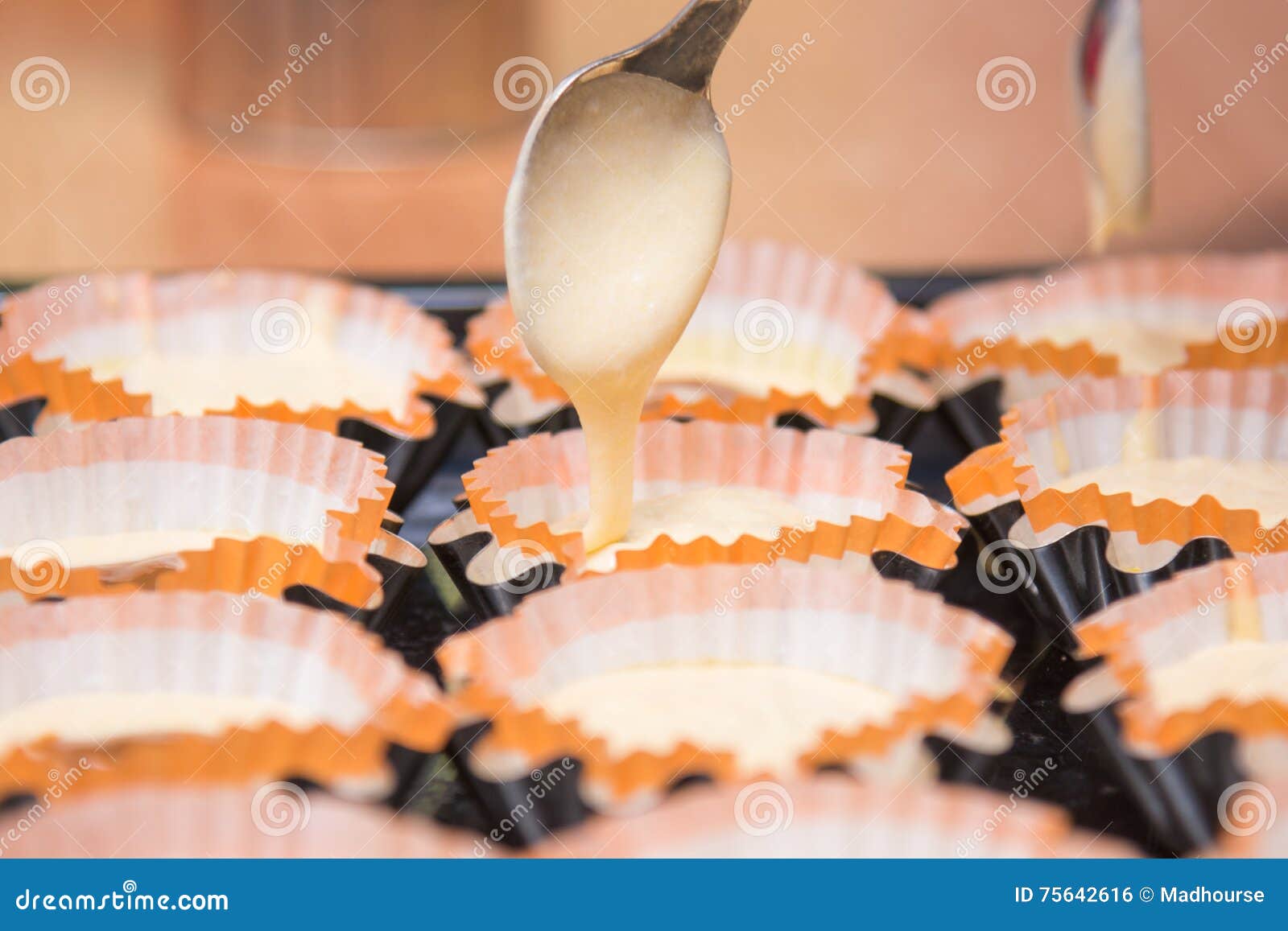 Dough for Cakes Dripping from a Spoon into Molds Stock Photo - Image of ...