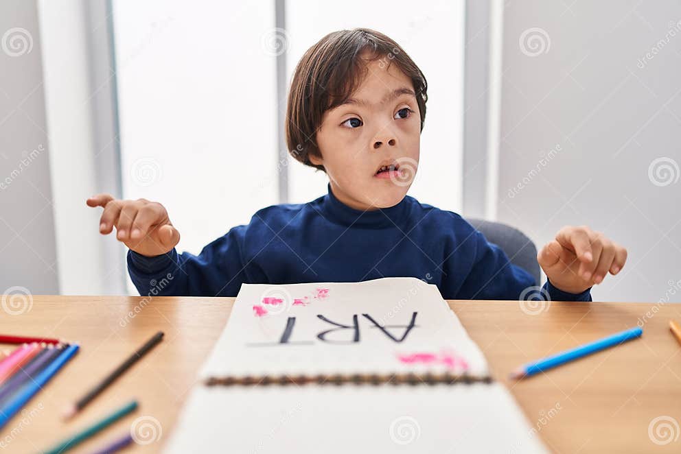 Down Syndrome Kid Drawing on Notebook at School Stock Image - Image of ...